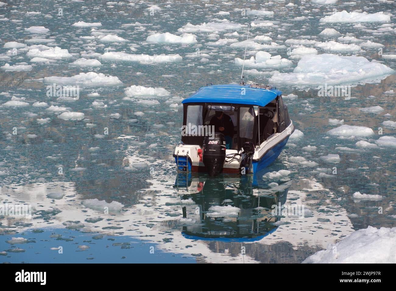 Small motorboat in dense drift ice, reflections, tranquillity, Knud ...