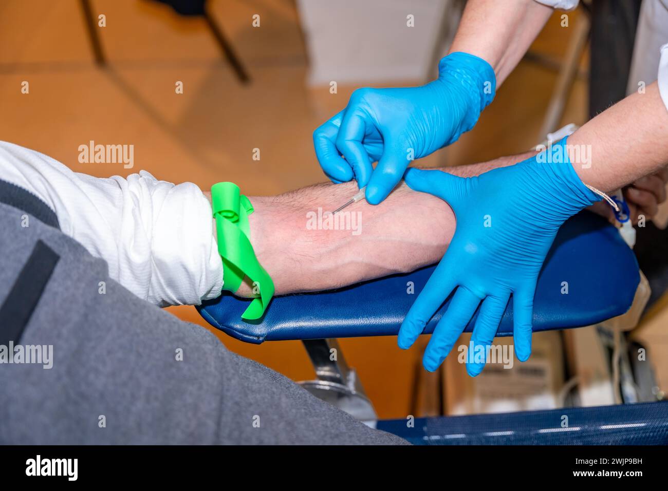 Close-up of the hands of a doctor carefully inserting a needle into the ...