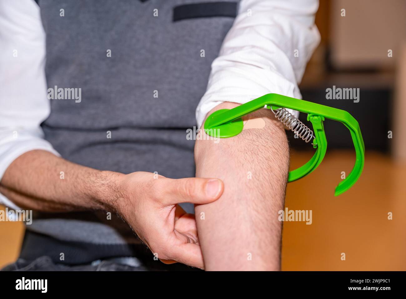 Close-up of an unrecognizable male volunteer pressing arm to prevent a ...