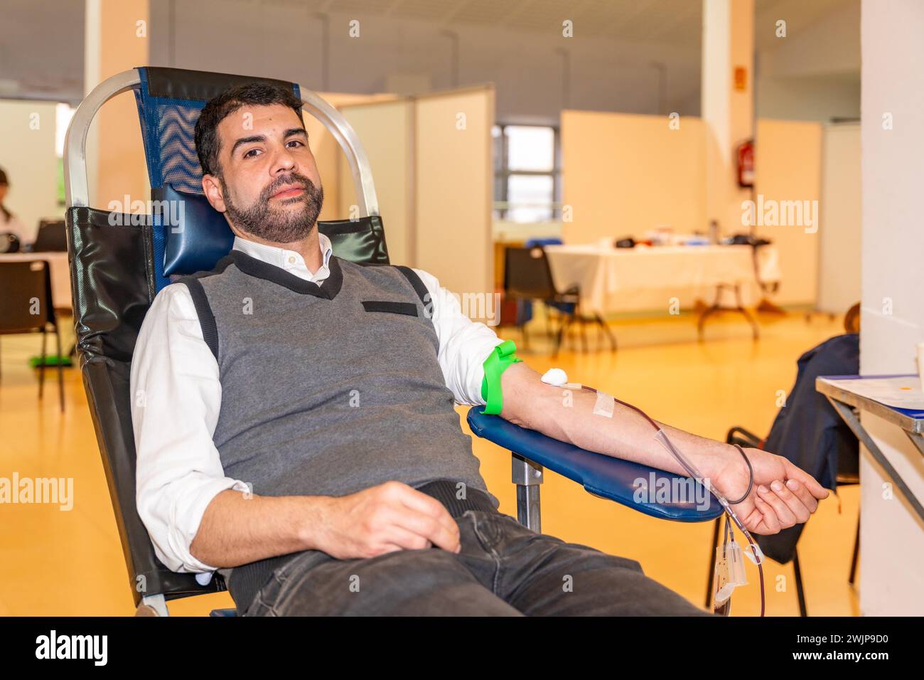 Volunteer looking at camera while lying in a chair during a blood ...