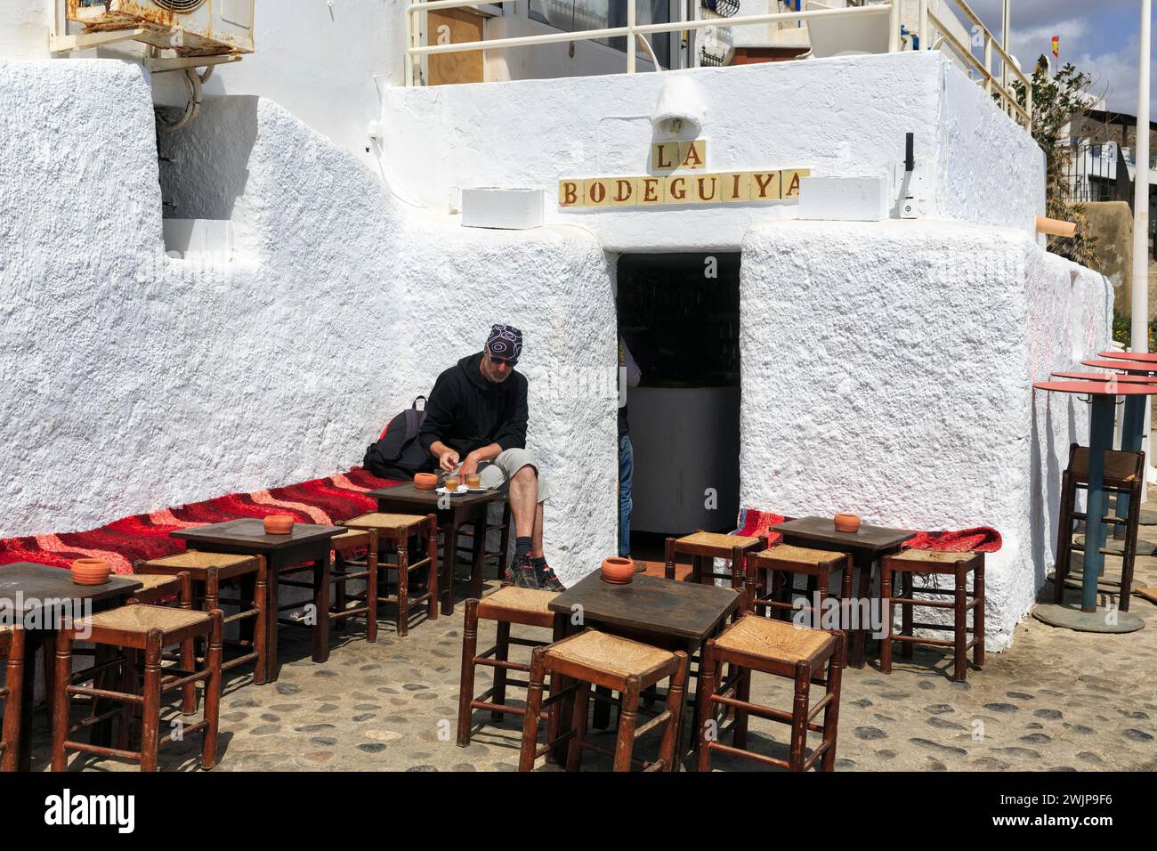 Tourist sitting at simple wooden tables outdoors, Bar La Bodeguiya ...
