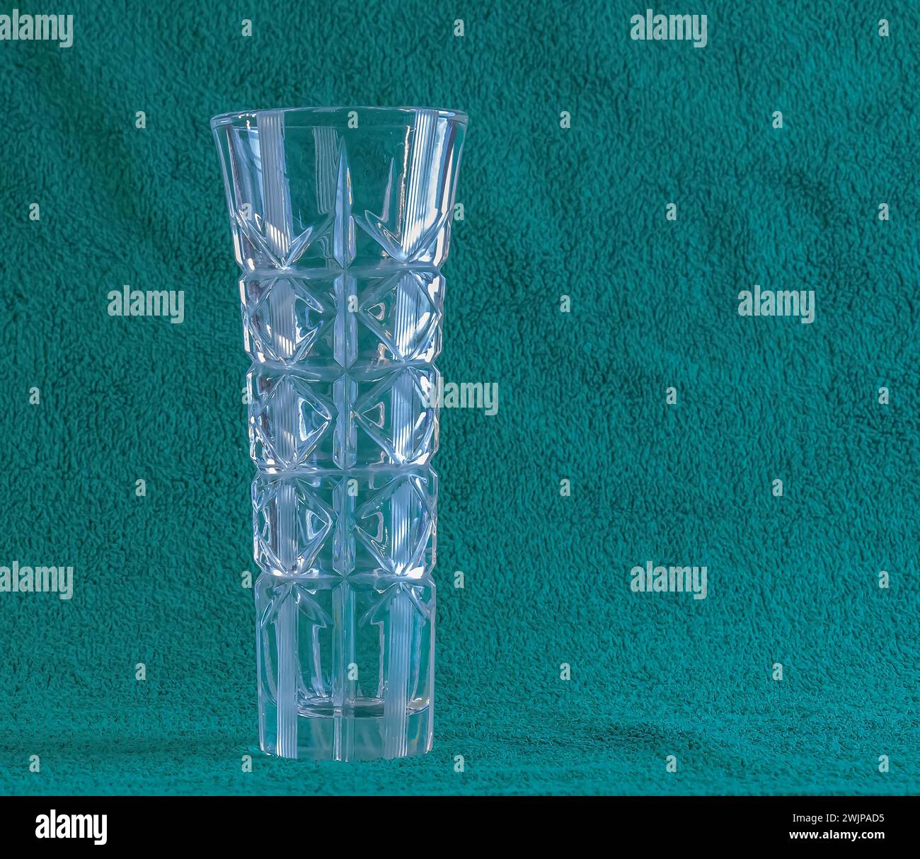 Empty crystal vase on green background. The vase was made in the mid ...