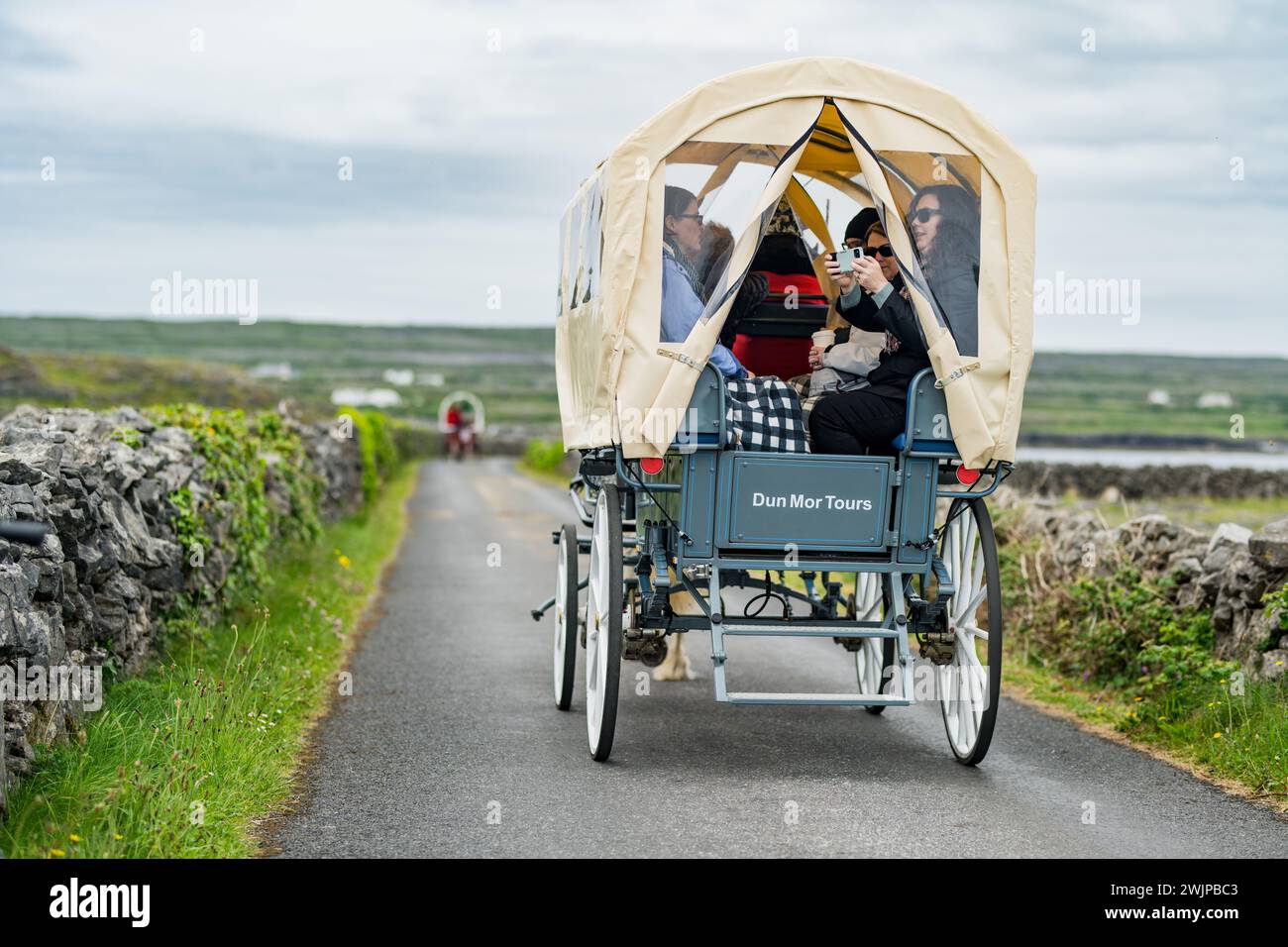 INISHMORE, IRELAND - 21 MAY, 2023: Tourists taking horse and carriage ...