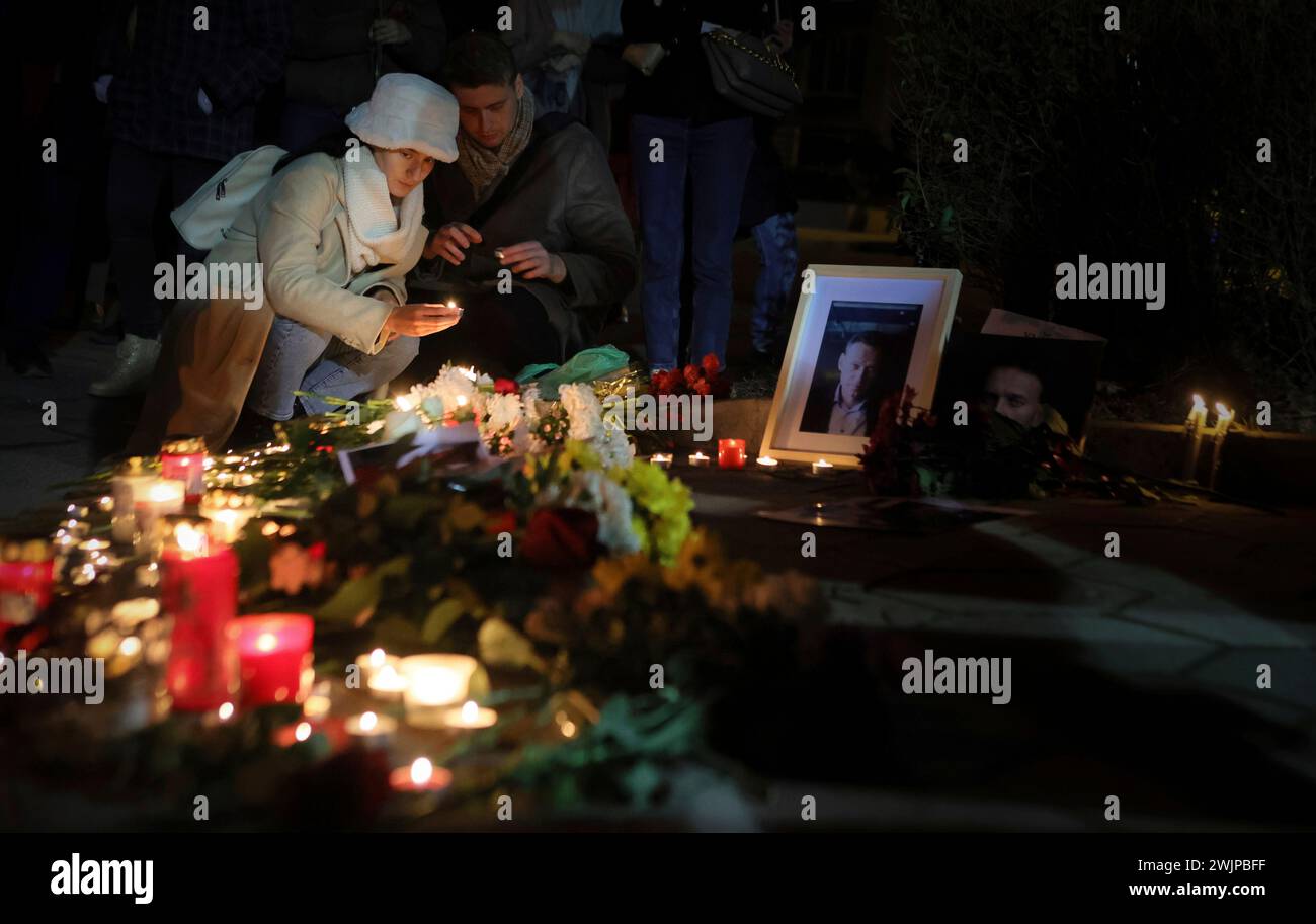 People light a candle as portraits of Alexei Navalny, candles and ...
