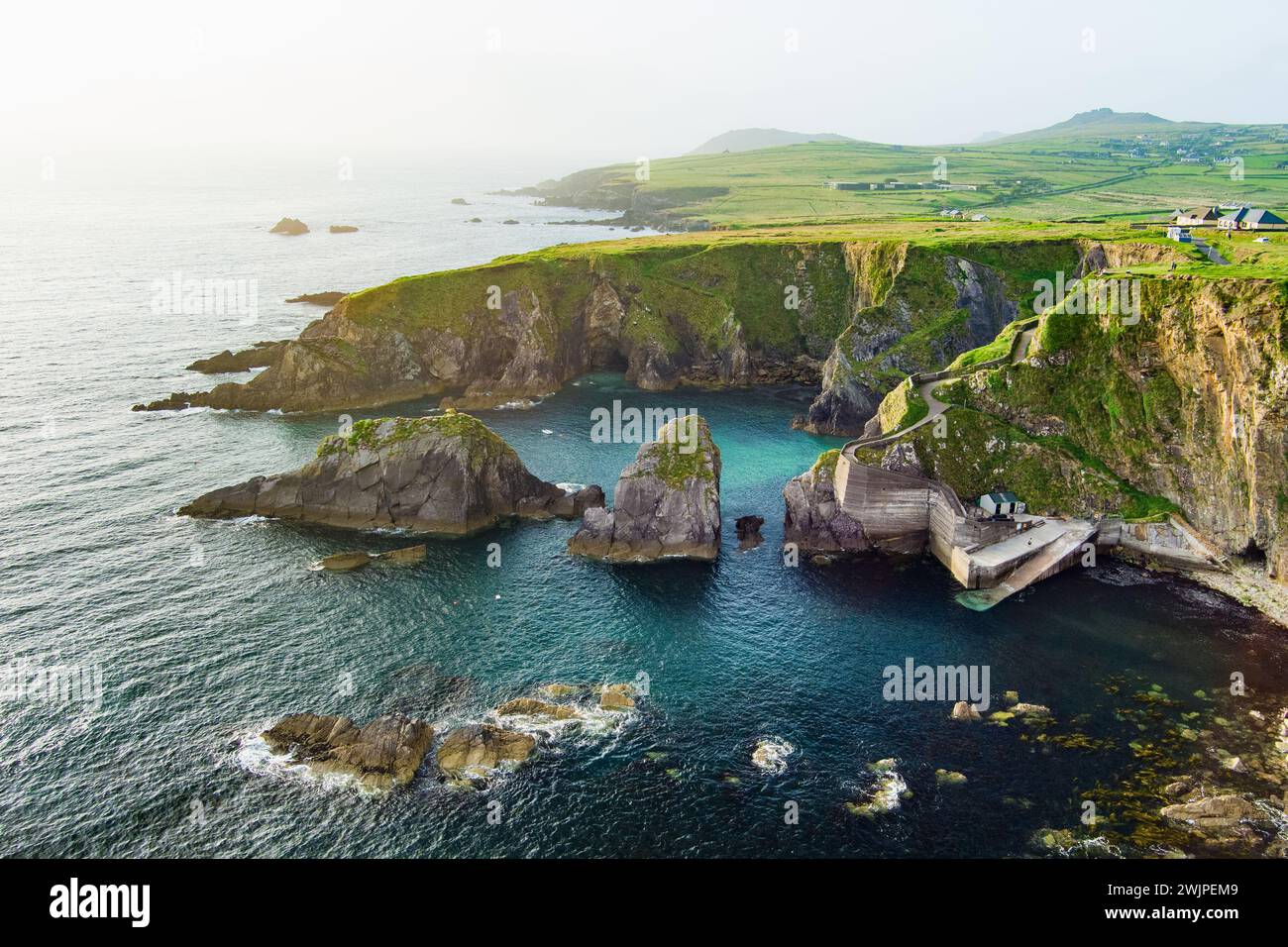 Dunquin or Dun Chaoin pier, Ireland's Sheep Highway. Aerial view of narrow pathway winding down ...