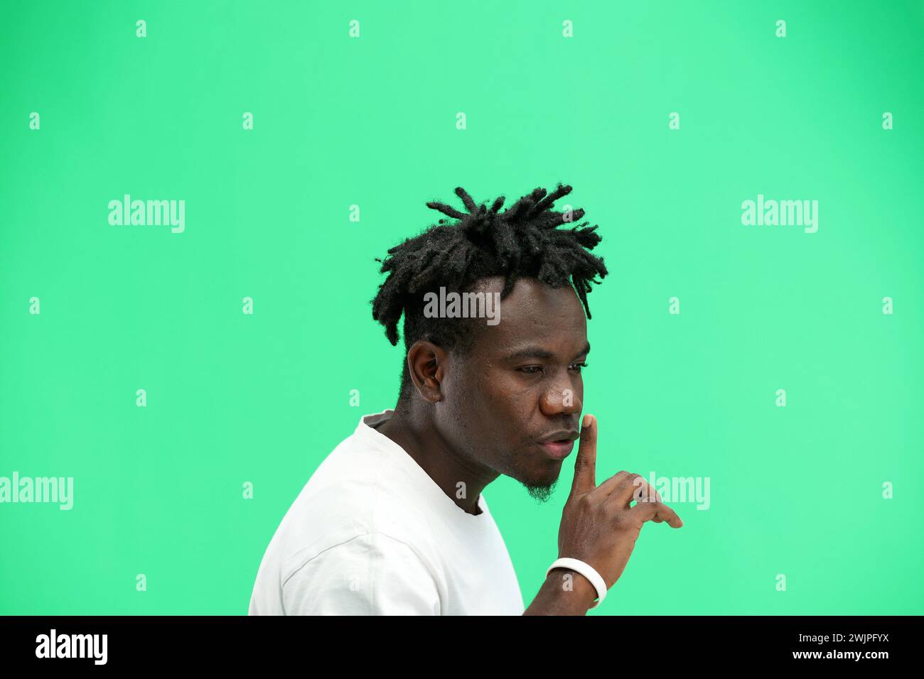 A man, close-up, on a green background, shows a sign of silence Stock ...