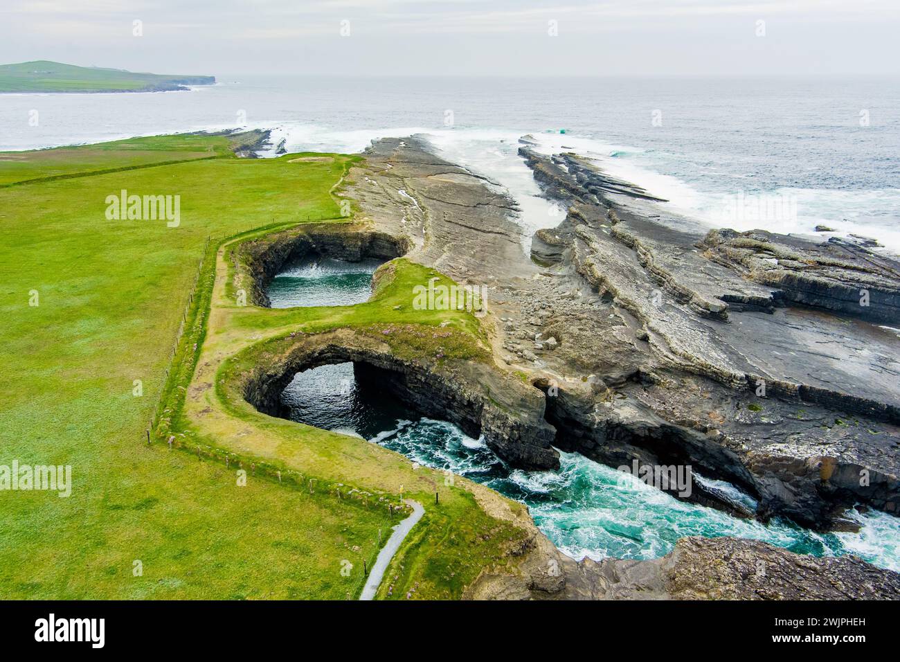 Aerial view of Bridges of Ross, three natural rock arches, carved into ...