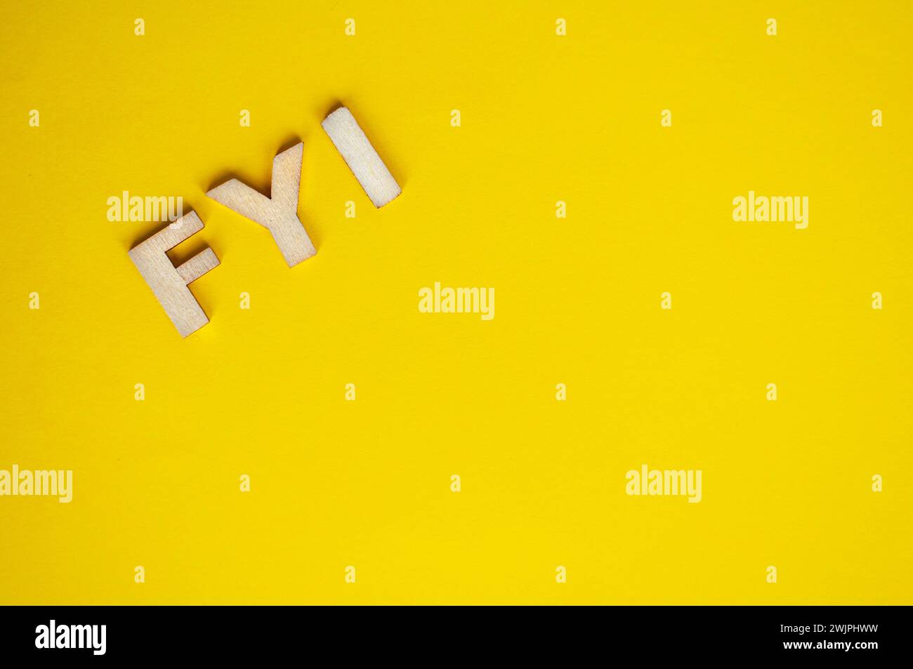 Top view of wooden FYI text on yellow background with customizable ...