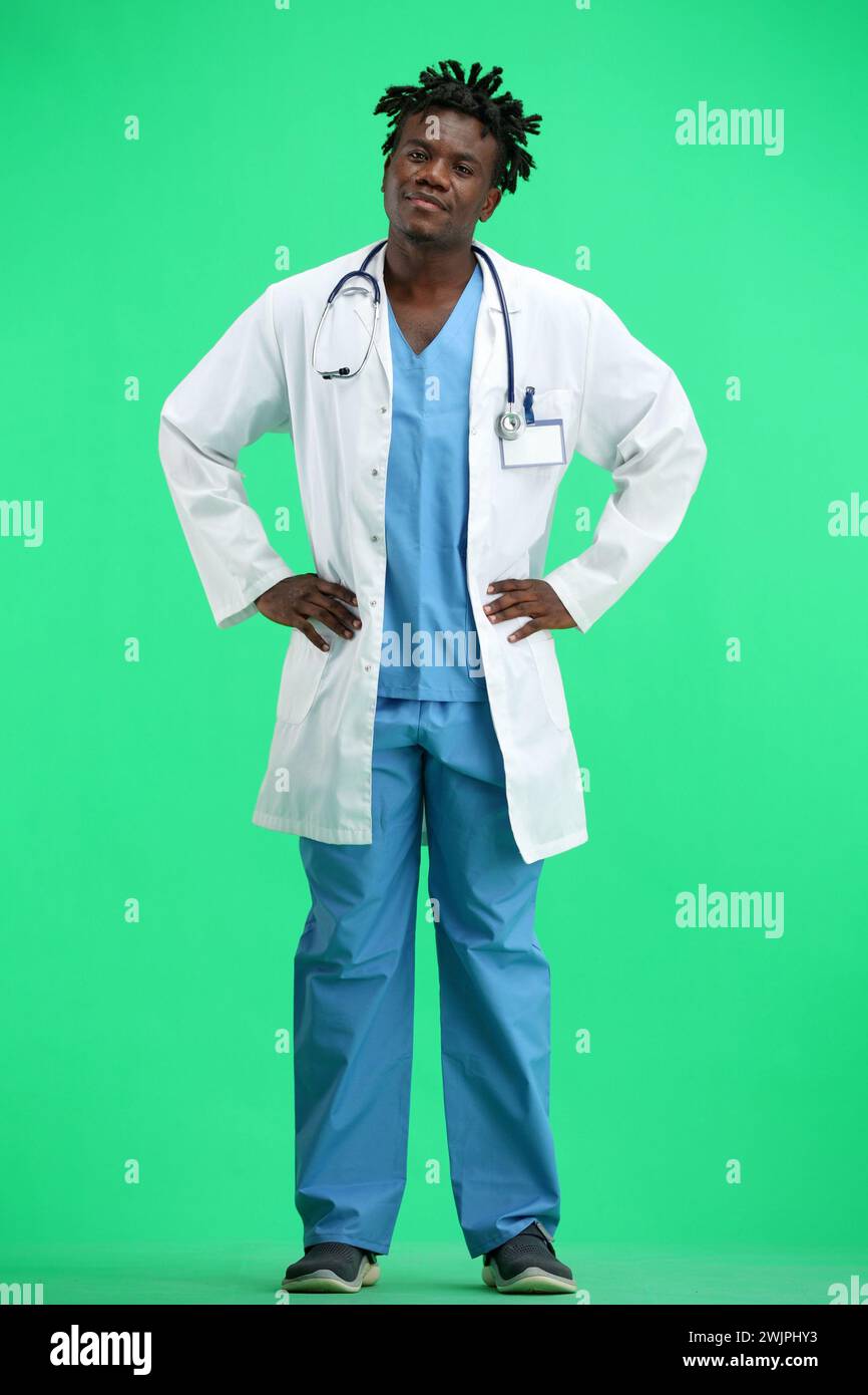 Doctor, full-length, on a green background, hands on hips Stock Photo ...
