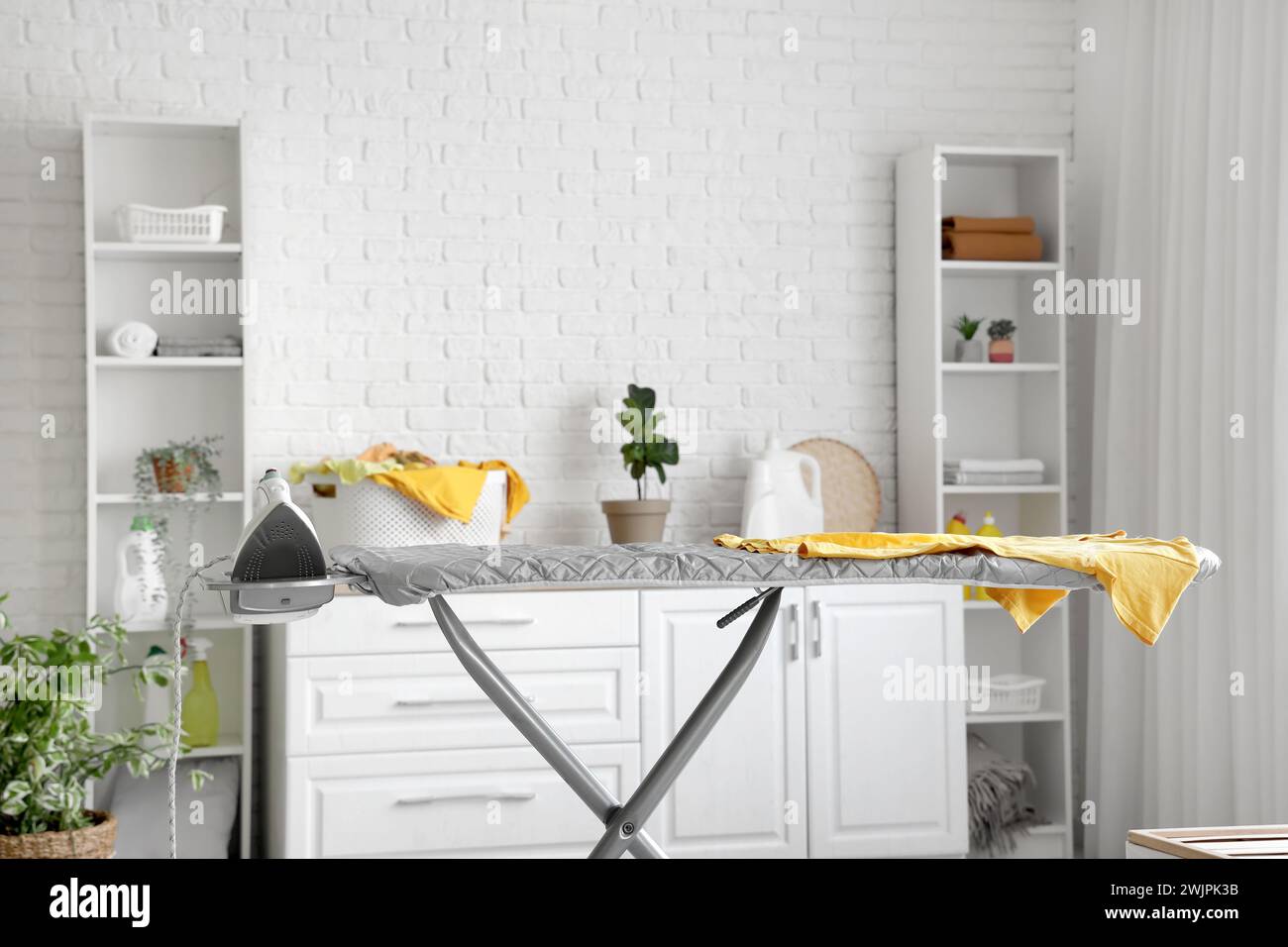 Interior of laundry room with ironing board and counters Stock Photo ...