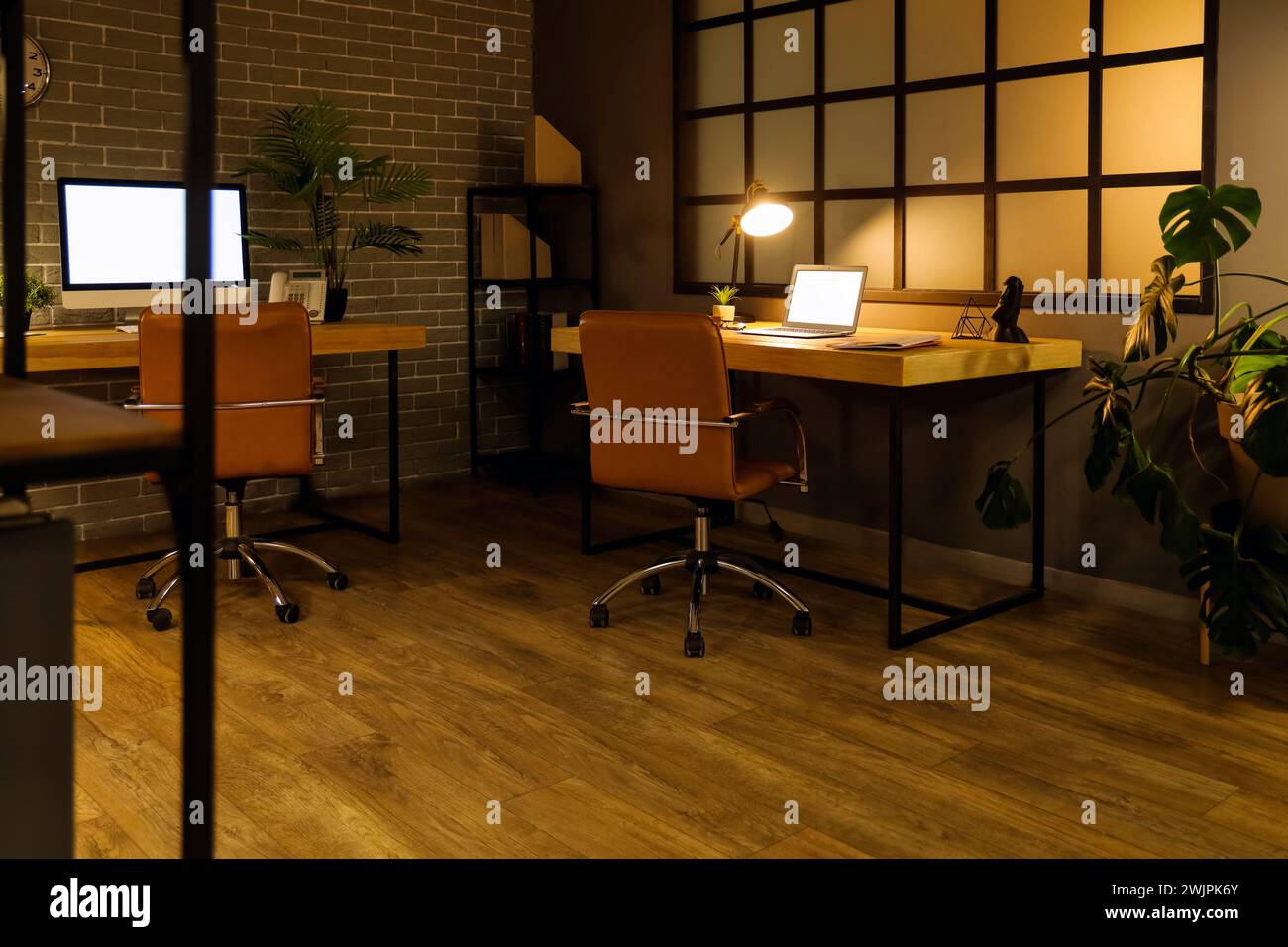 Interior of dark office with desks and glowing lamp at night Stock ...