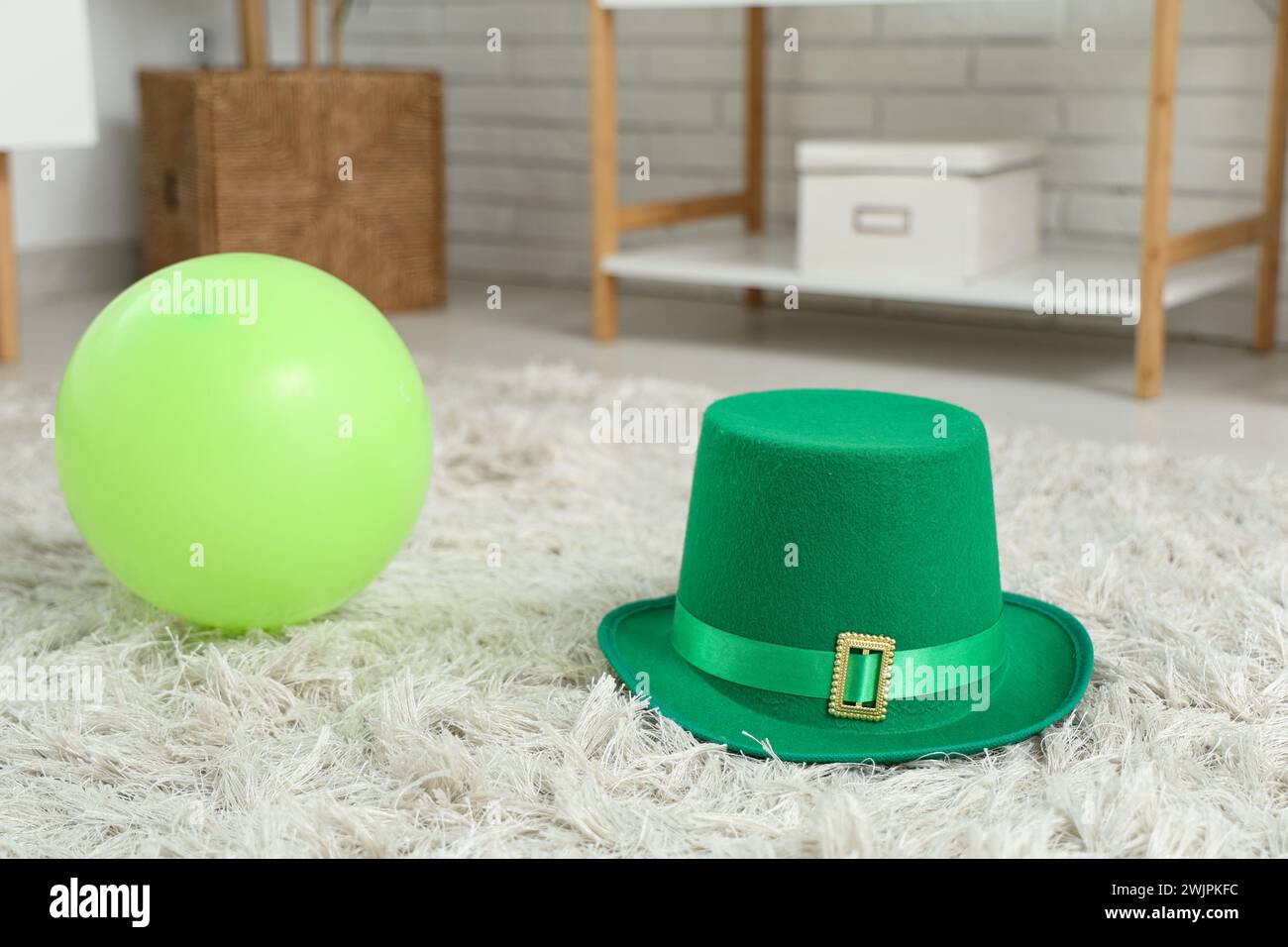 Leprechaun's hat and green balloon on floor in living room. St. Patrick ...