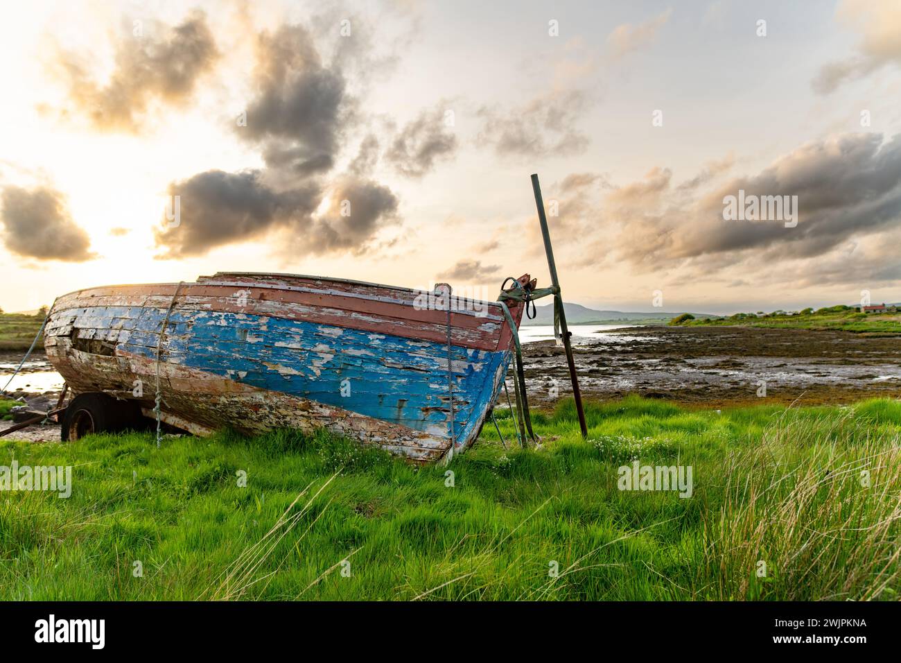 Old boat left on a small beach along the Ring of Kerry route. Rugged ...
