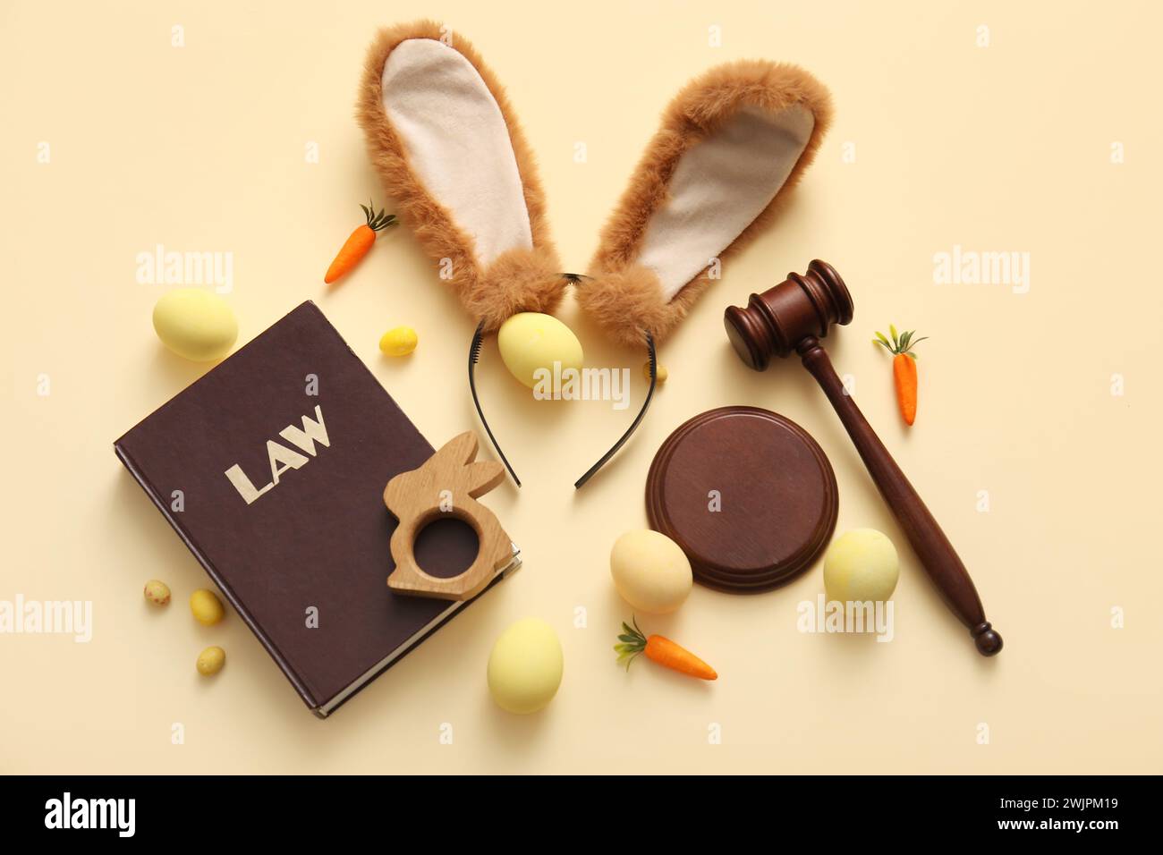 Bunny ears with Easter eggs, law book and judge's gavel on beige ...