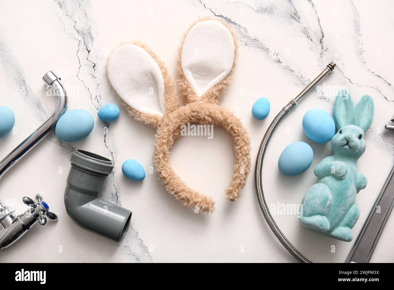 Bunny ears with Easter eggs and plumber supplies on white marble ...