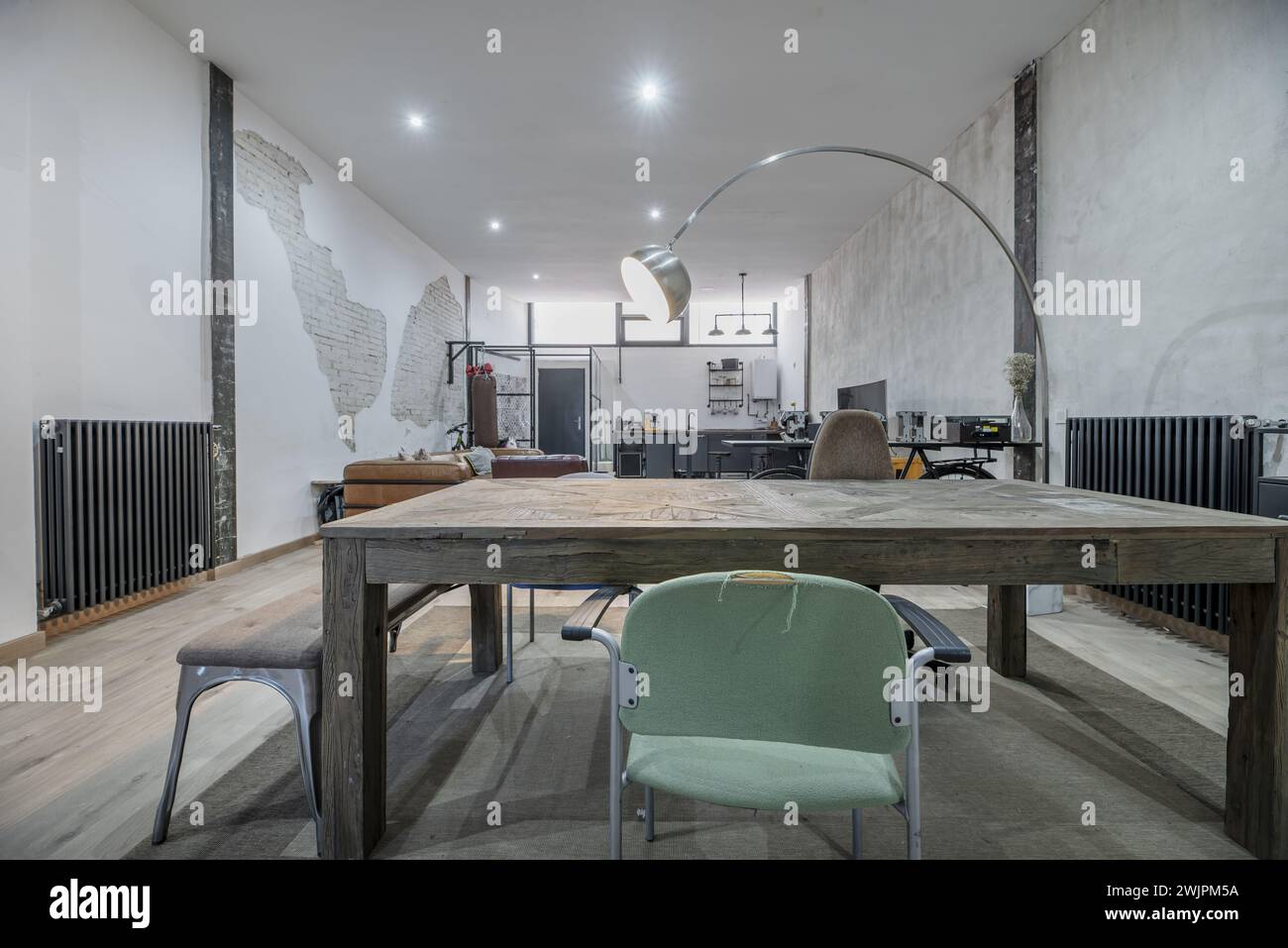 Large living room in a loft-type house, unvarnished wooden table, open ...