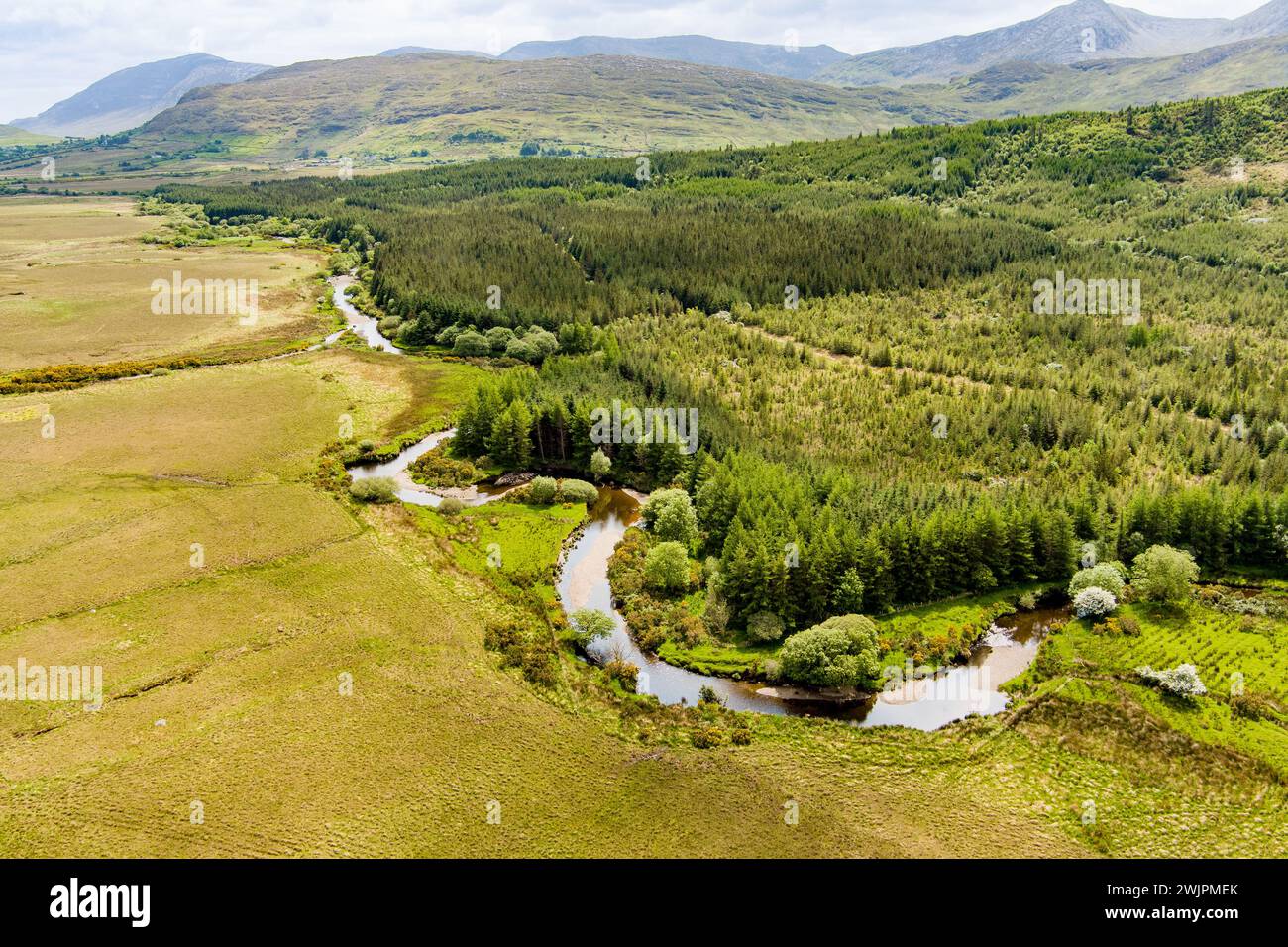 Aerial view of Joyce's river winding down below in Connemara region in ...