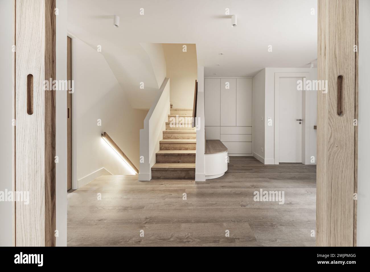 Entrance hall of a detached house with a wooden seat with large drawers ...