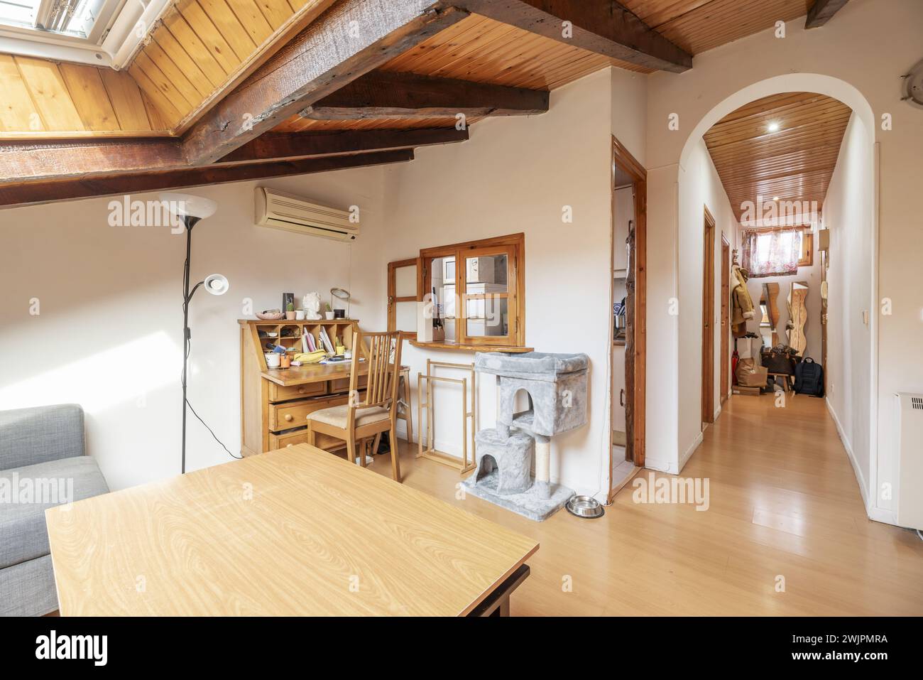 A living room of a flat attic home with mansard ceilings with pine wood ...