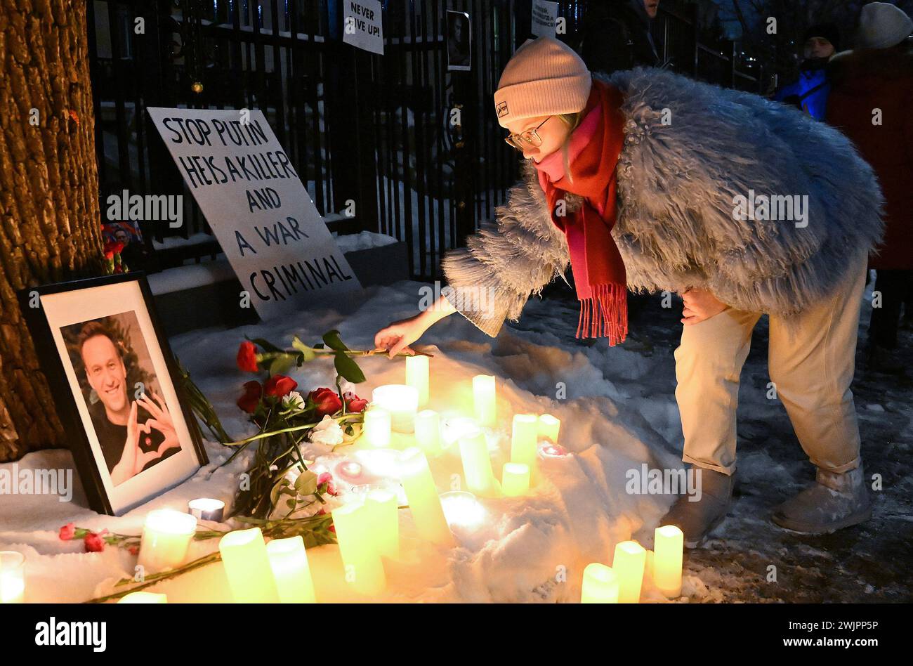 A person places a flower at a makeshift memorial for Alexei Navalny ...