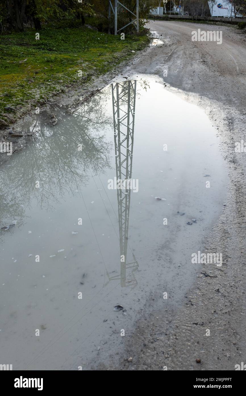 A large puddle of rainwater reflecting on the surface of a high voltage tower Stock Photo - Alamy