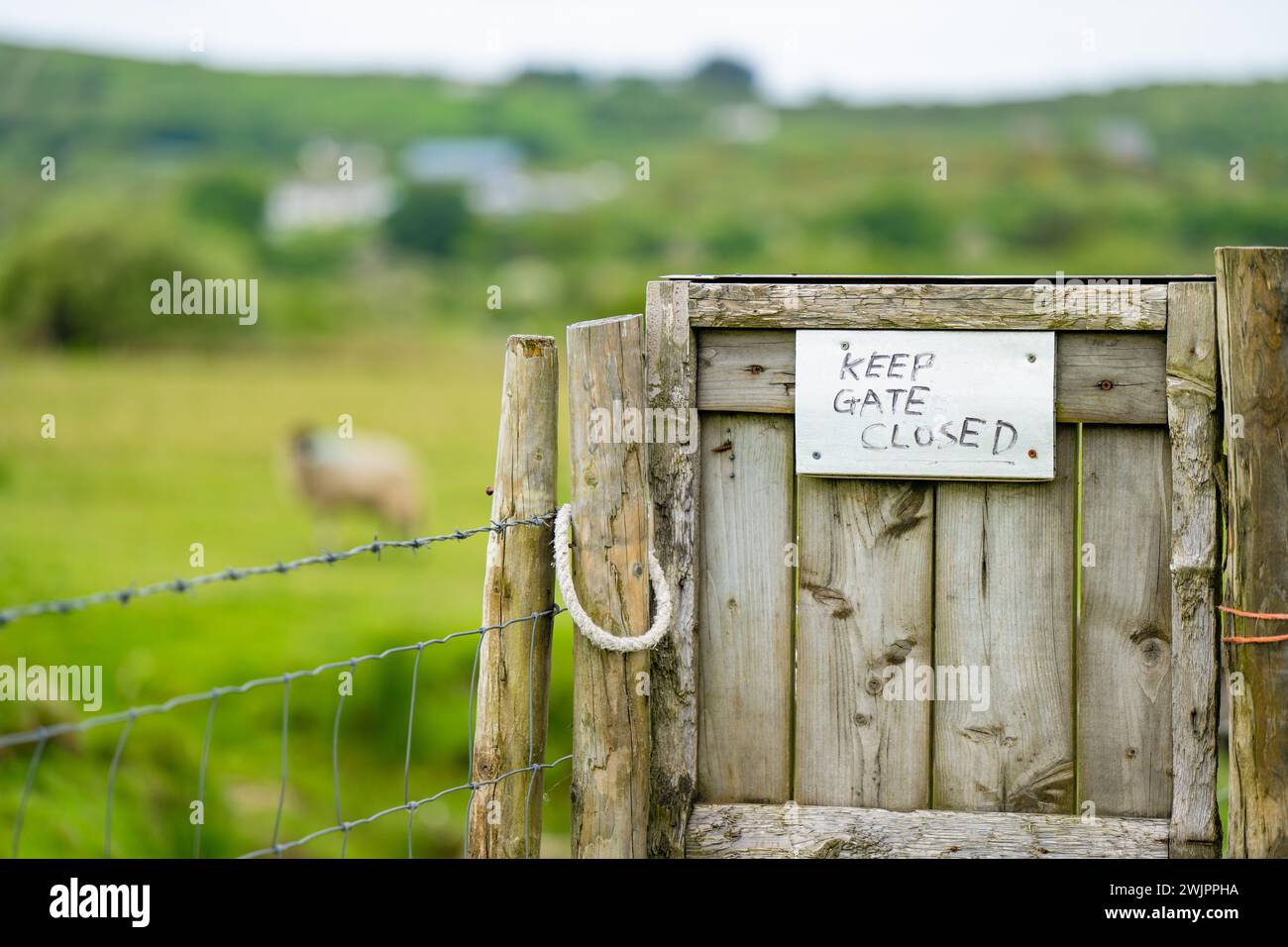 Closed wooden gate with a request to keep it closed in Irish pastures ...