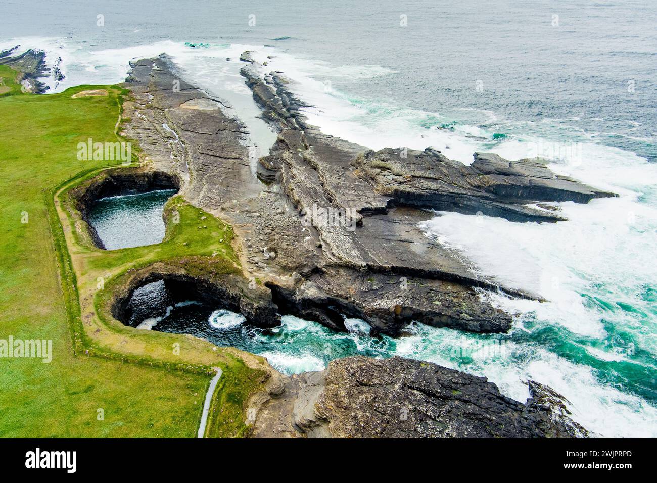 Aerial view of Bridges of Ross, three natural rock arches, carved into ...