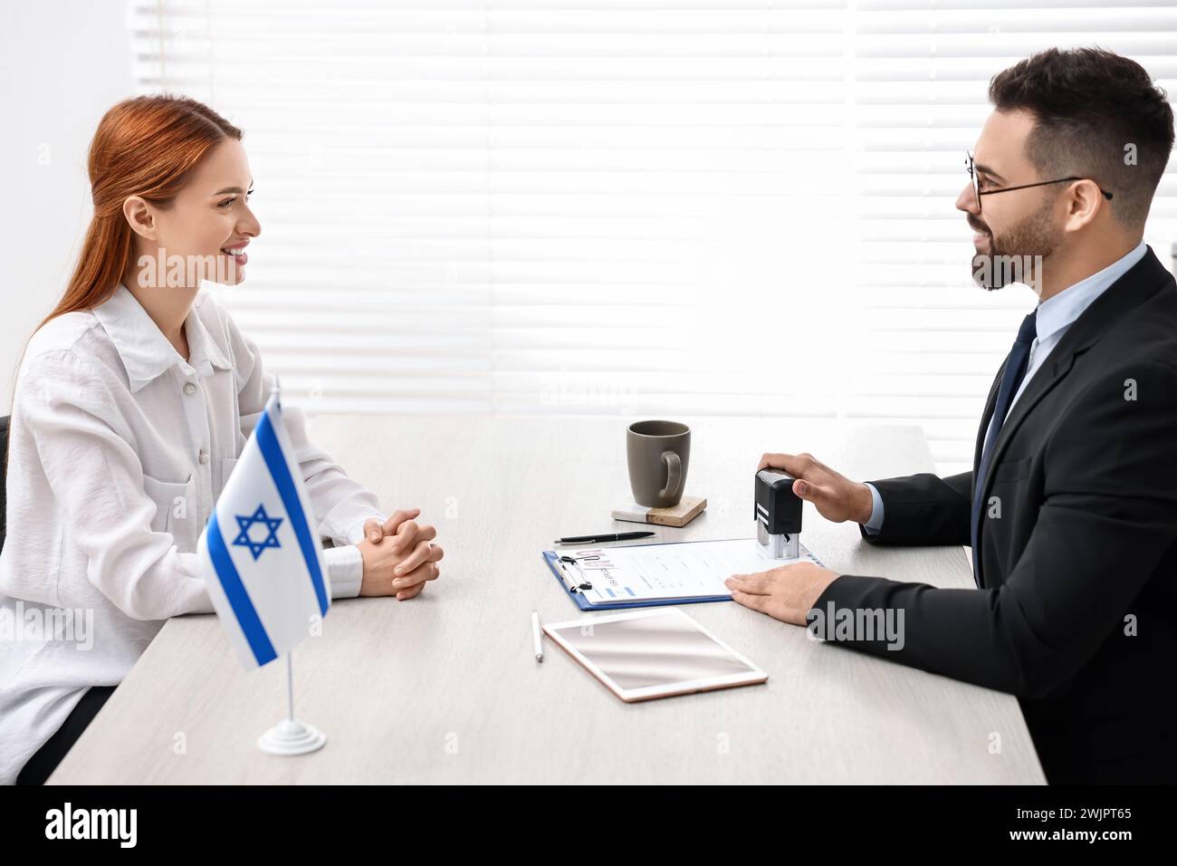 Immigration to Israel. Embassy worker approving visa application form ...