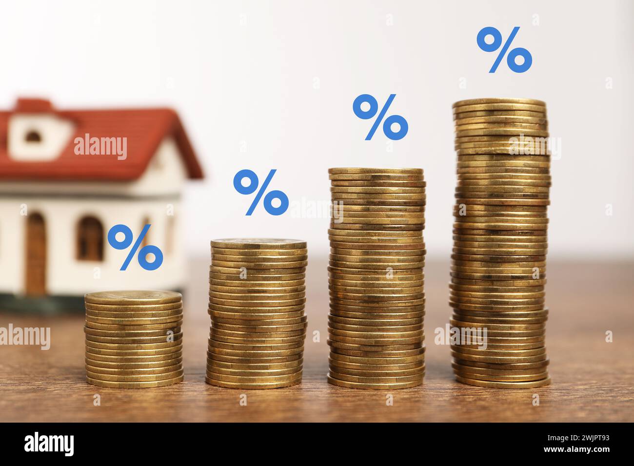 Mortgage rate. Stacked coins, percent signs and model of house Stock ...