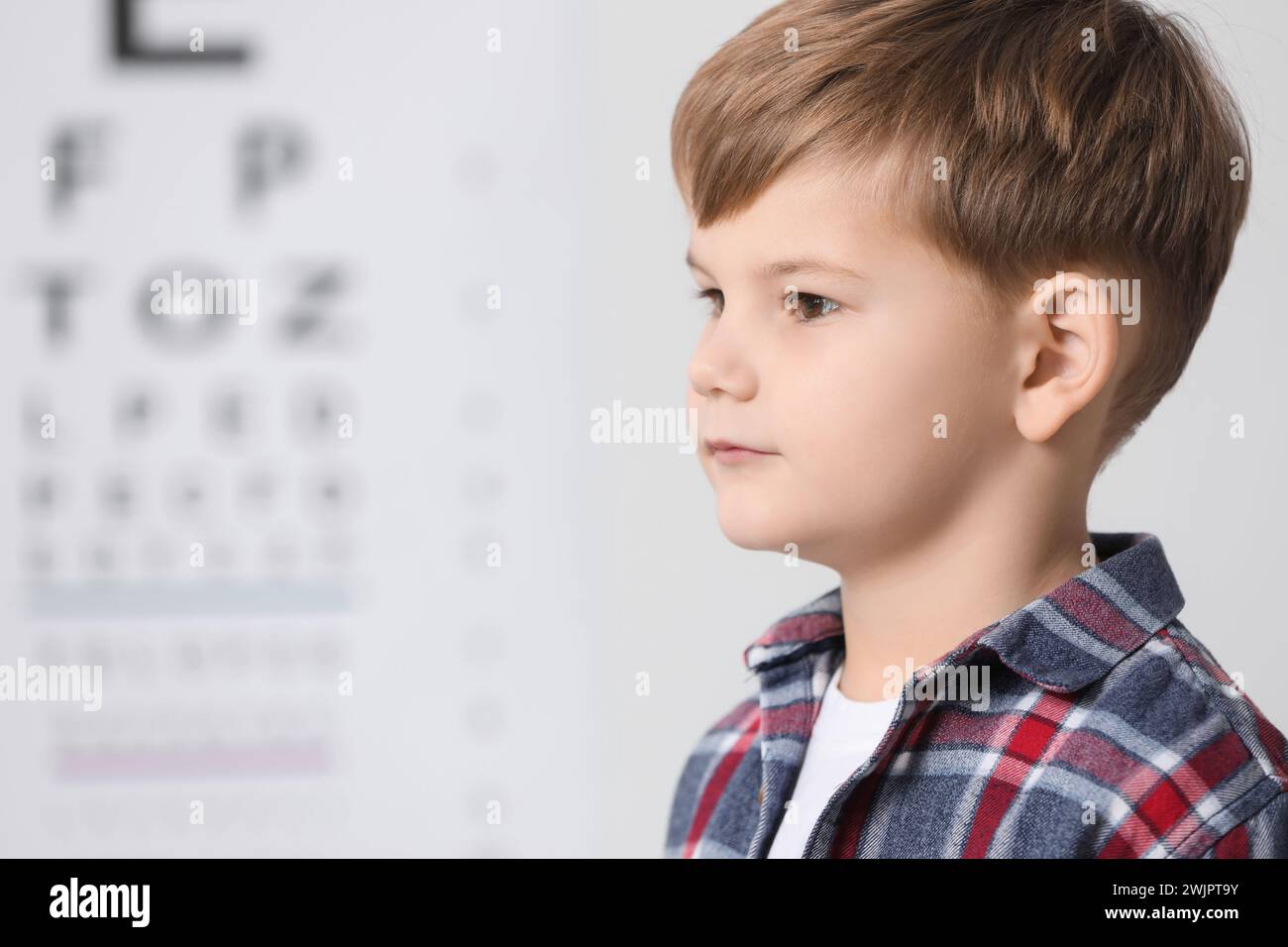 Cute little boy against vision test chart Stock Photo - Alamy