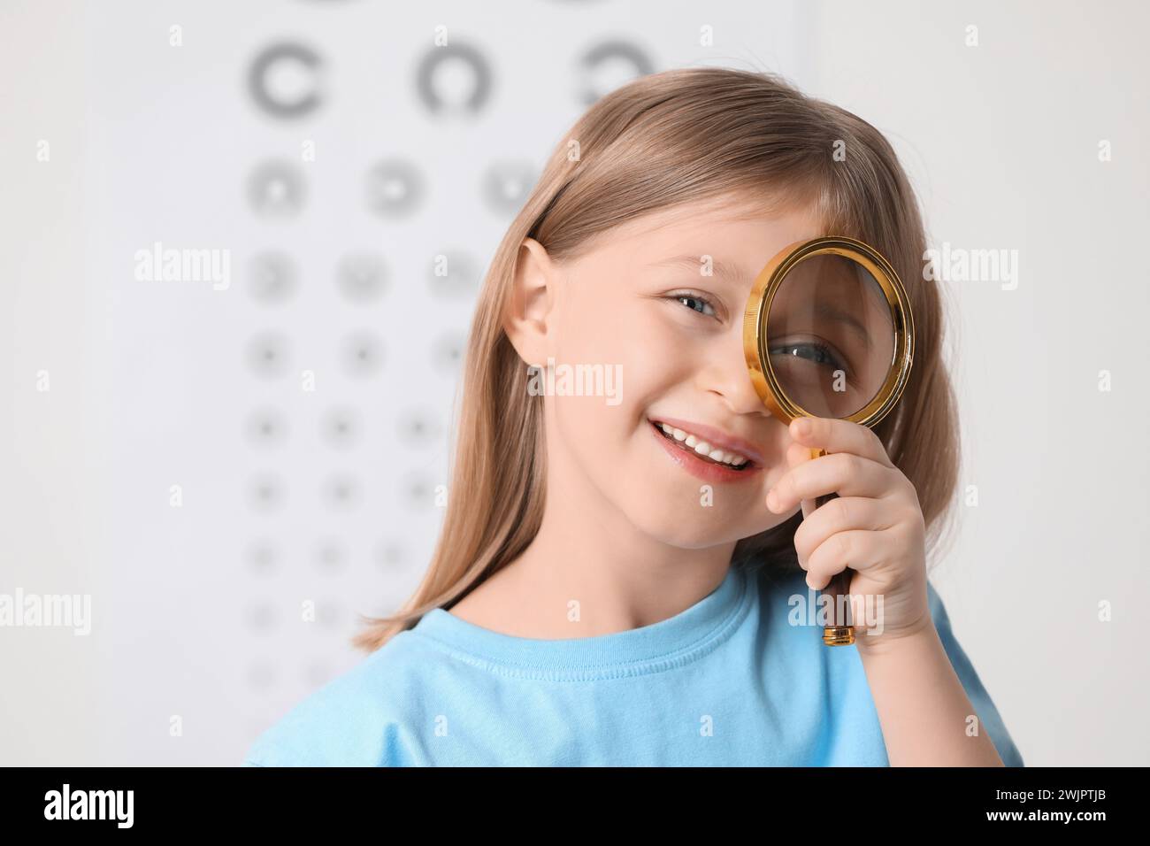 Little girl with magnifying glass against vision test chart Stock Photo ...