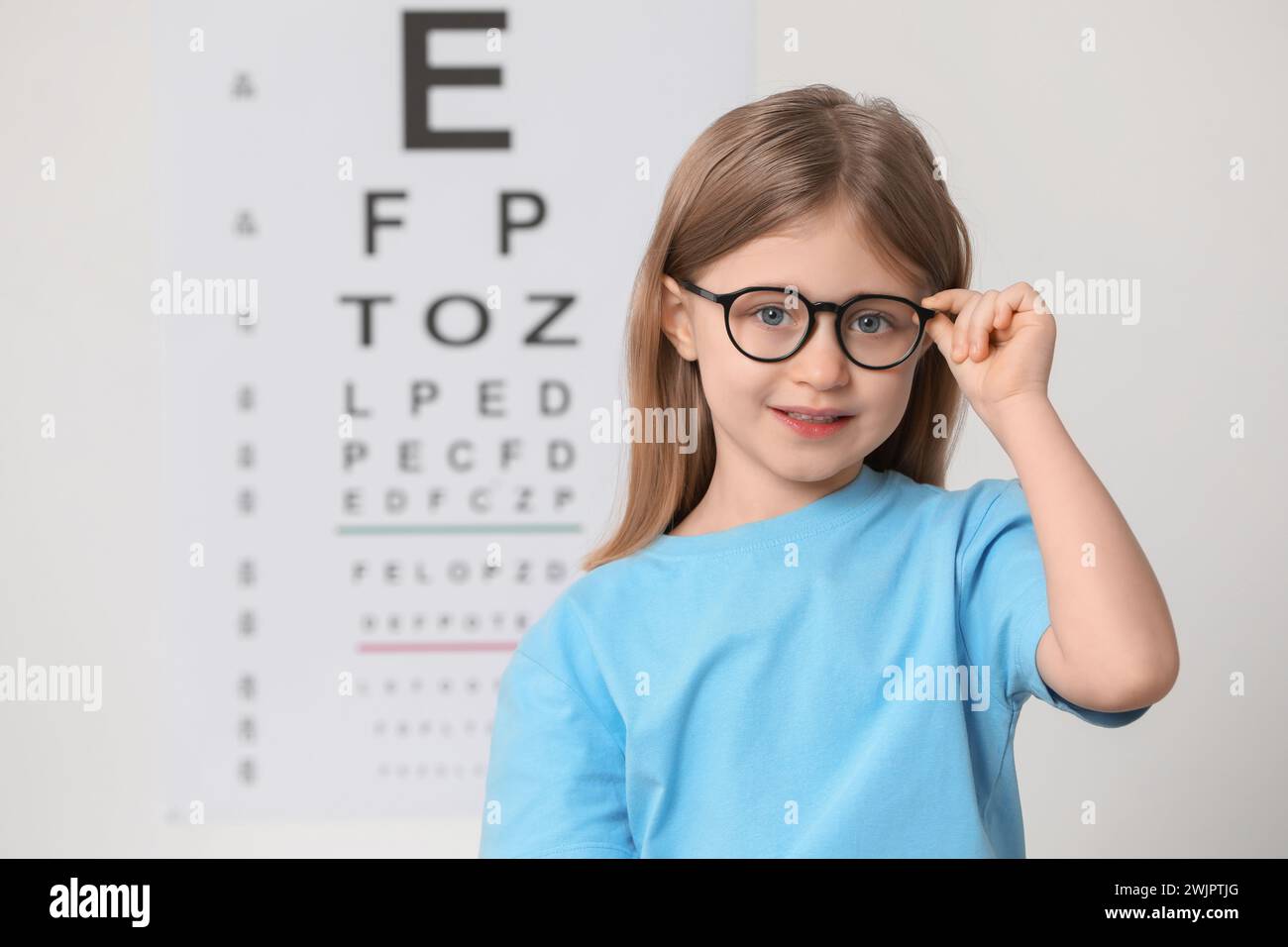 Little girl with glasses against vision test chart Stock Photo - Alamy