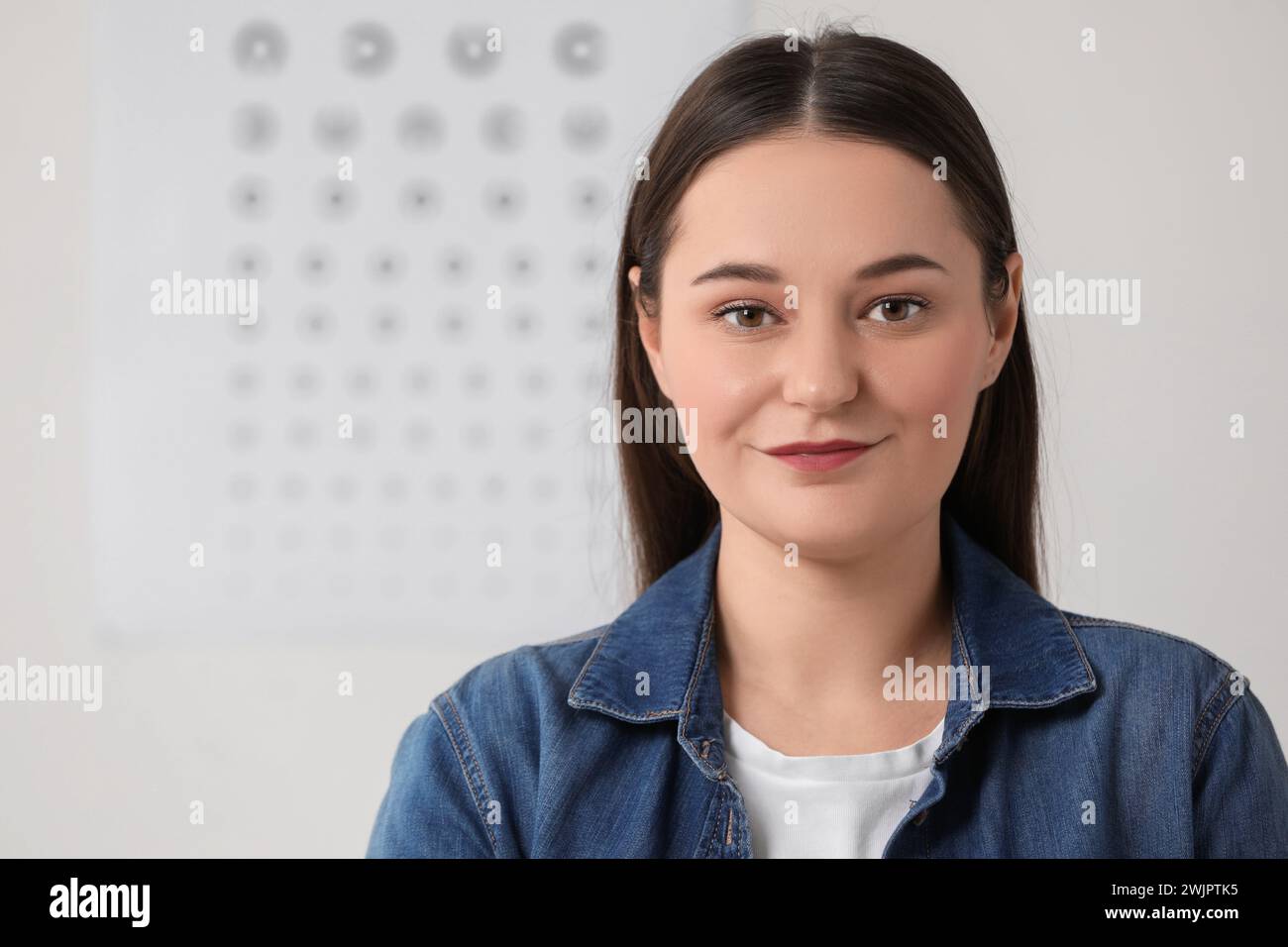 Portrait of young woman against vision test chart Stock Photo - Alamy