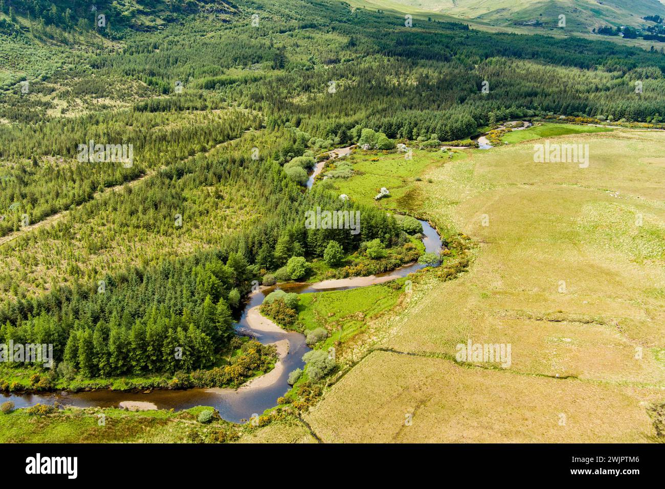 Aerial view of Joyce's river winding down below in Connemara region in ...