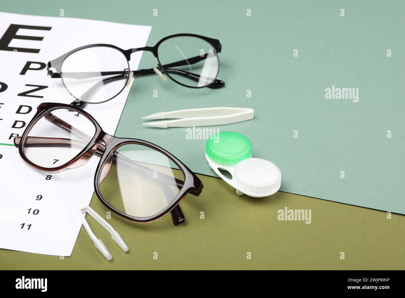 Vision test chart, glasses, lenses and tweezers on color background ...