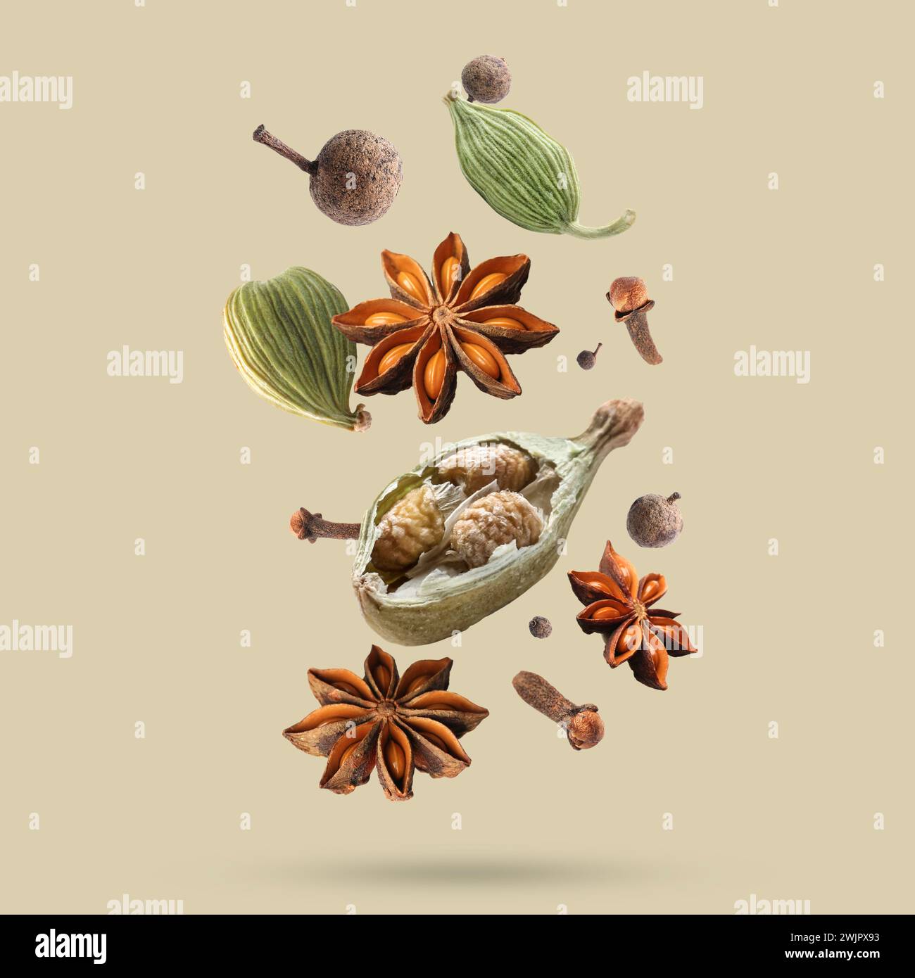 Different spices falling on dark beige background Stock Photo - Alamy