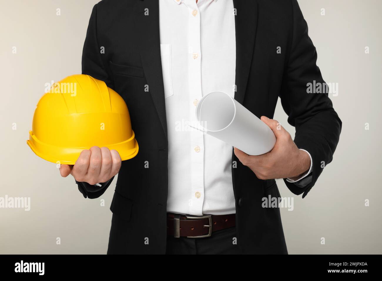 Architect with hard hat and draft on gray background, closeup Stock ...