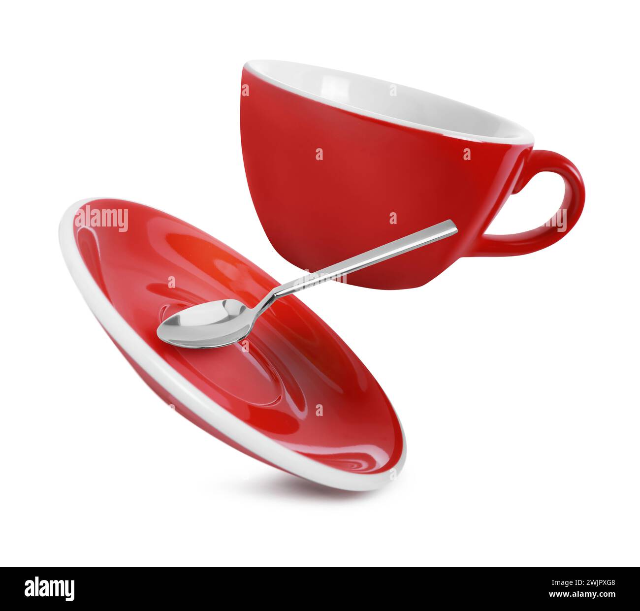 Spoon, cup and saucer falling on white background Stock Photo - Alamy