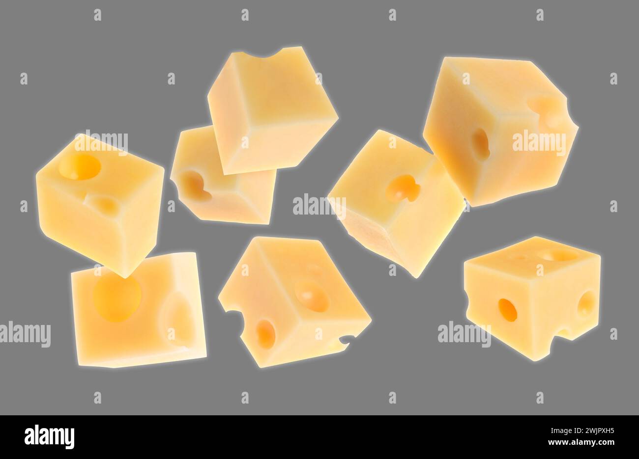 Pieces of cheese flying on grey background Stock Photo - Alamy