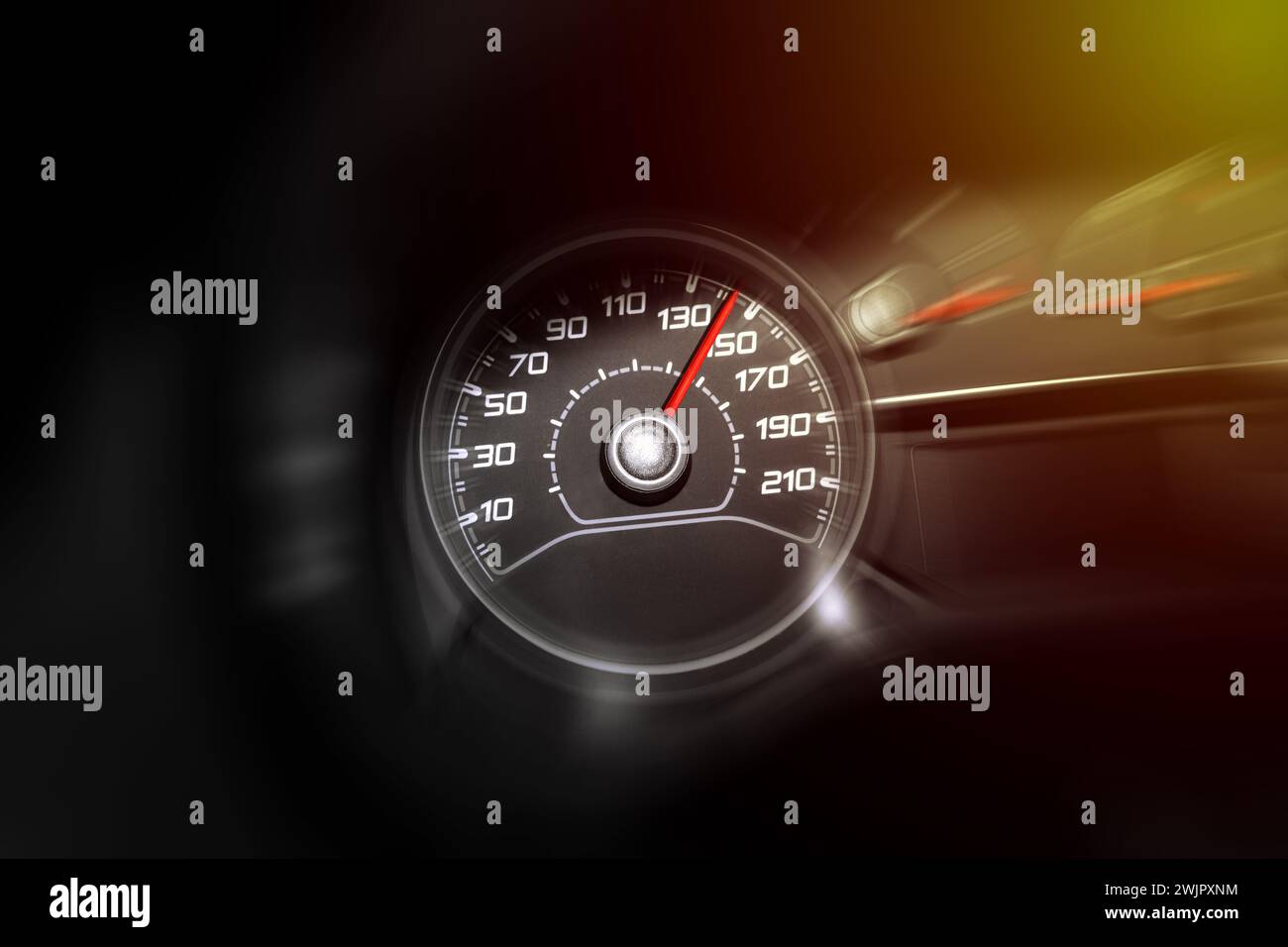 Speedometer on car dashboard under yellow light, closeup. Motion blur ...