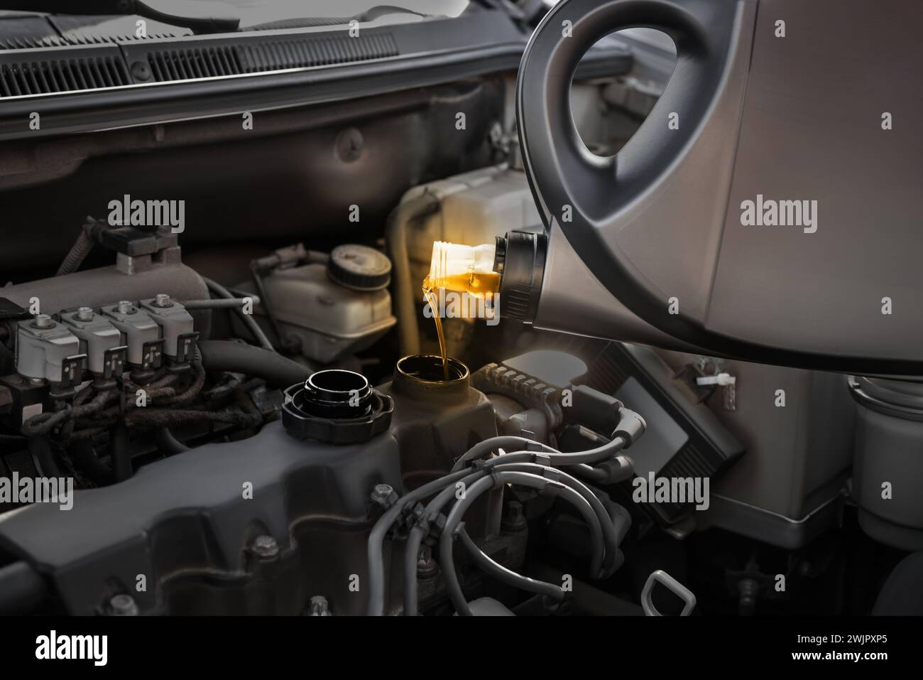 Pouring motor oil into car engine, closeup. Color accent effect Stock ...