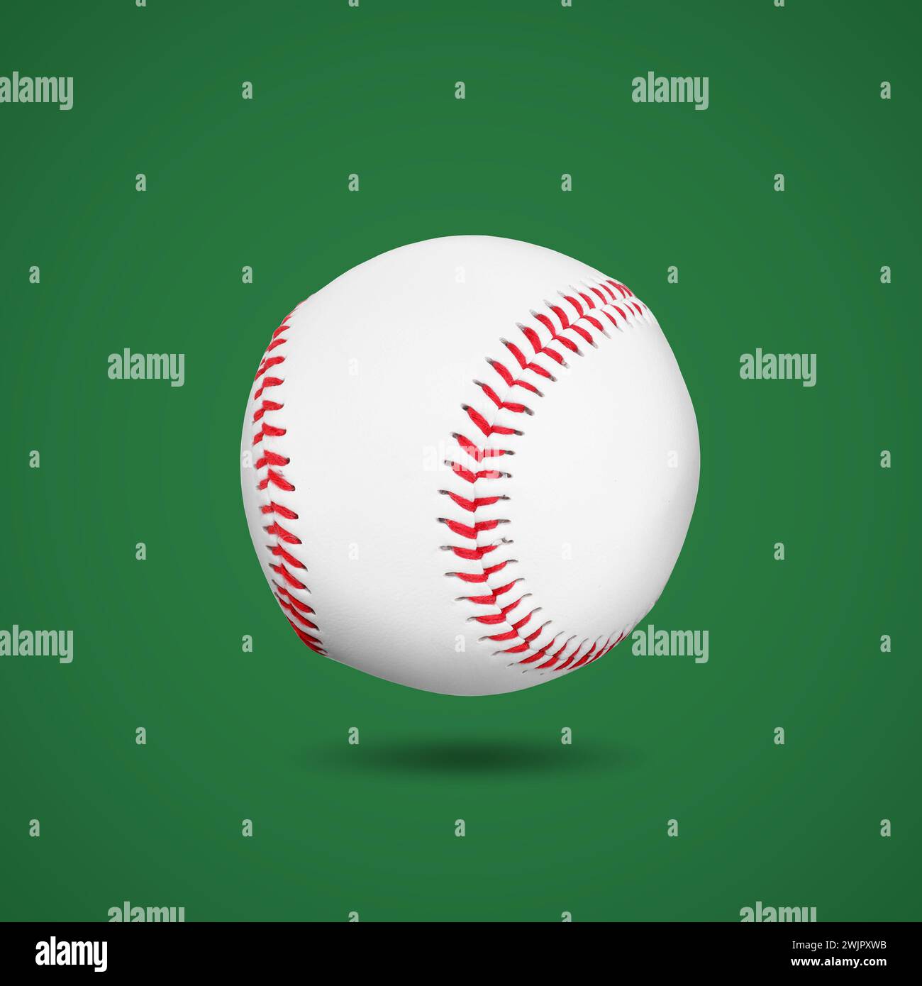 One baseball ball in air on green background Stock Photo - Alamy