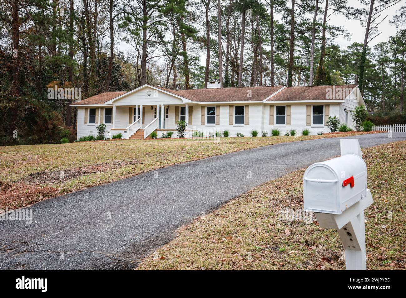 The front exterior entrance of a newly painted white siding brick ranch ...