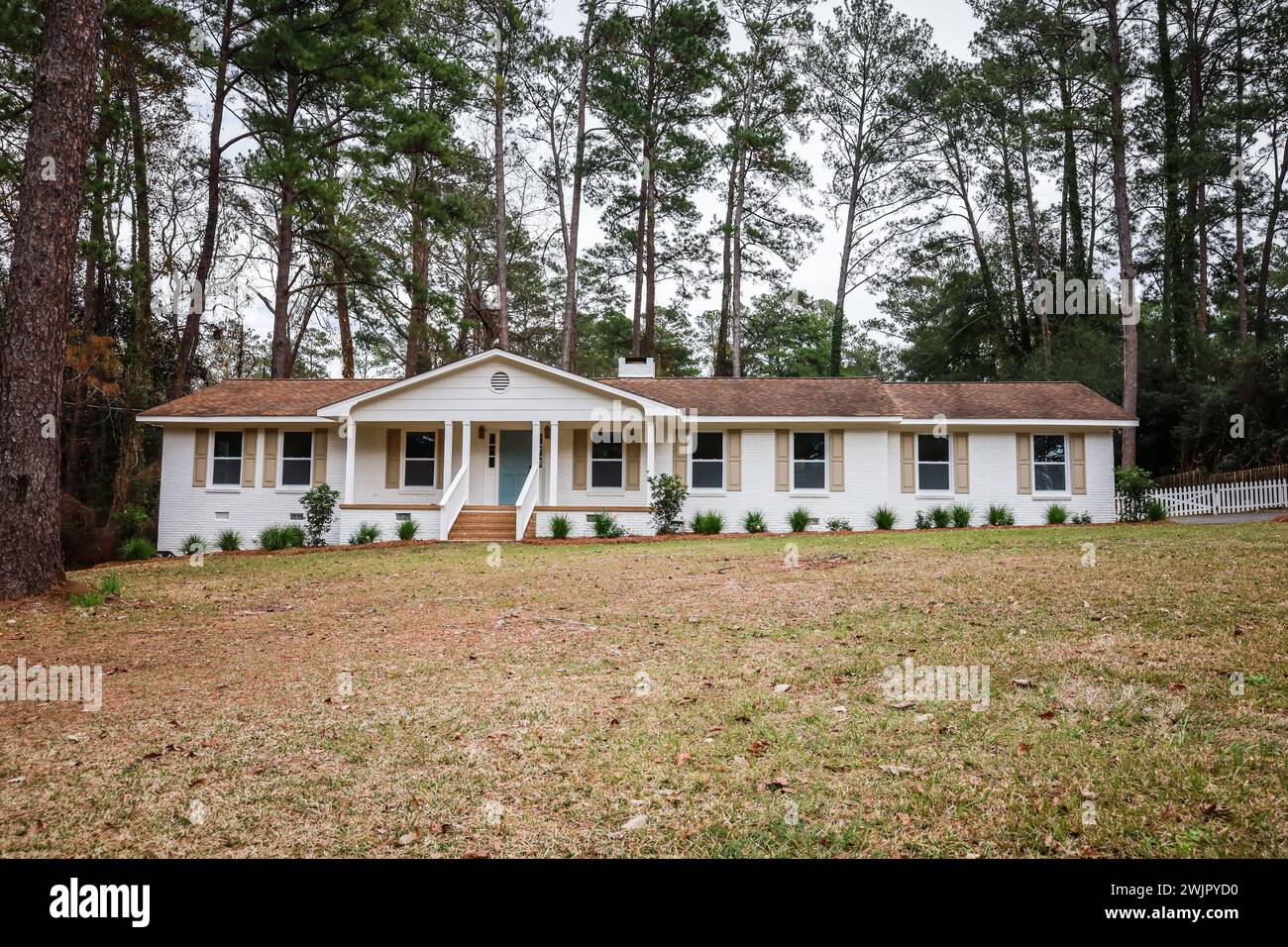 The front exterior entrance of a newly painted white siding brick ranch ...