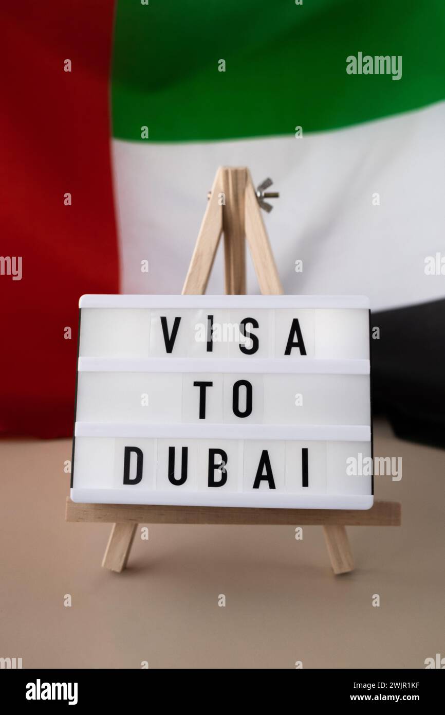 Lightbox with text VISA TO DUBAI on background of waving UAE flag made ...