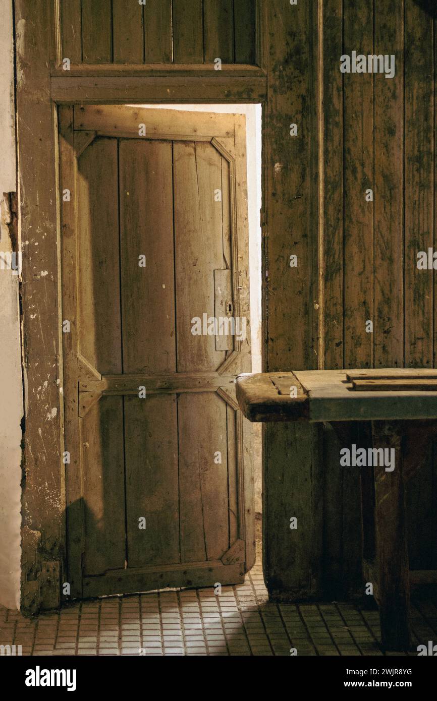 Old open wooden door through which the light enters and goes to the ...