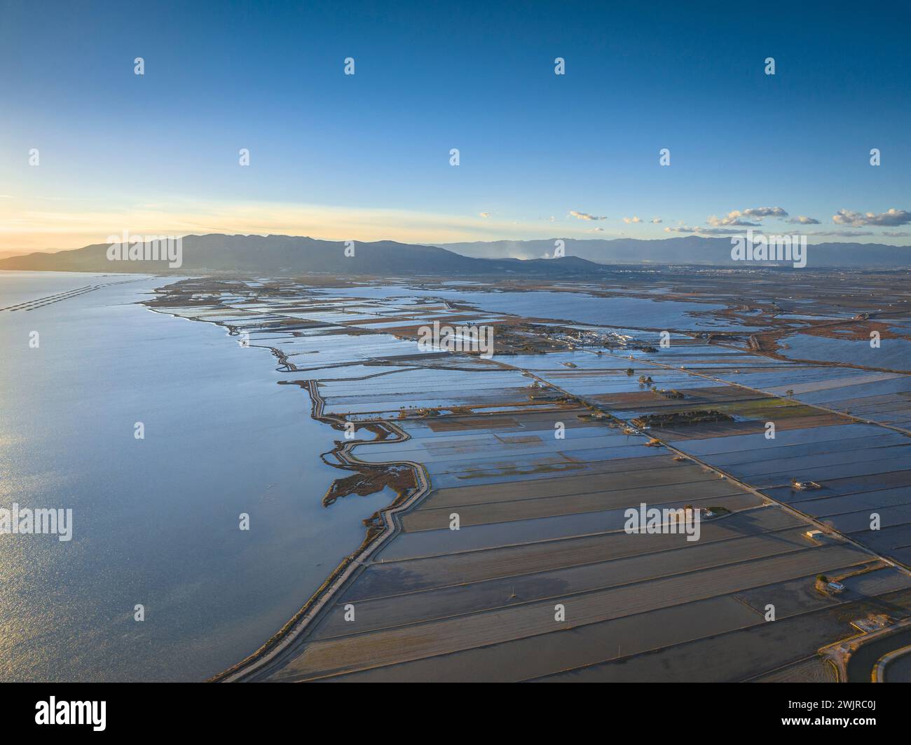 Aerial view of the Alfacs bay and the rice fields on a winter sunset in ...