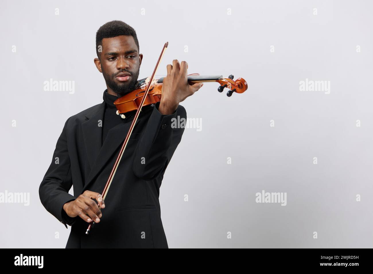 Elegant African American man playing the violin in a tuxedo on a white background concept Stock ...