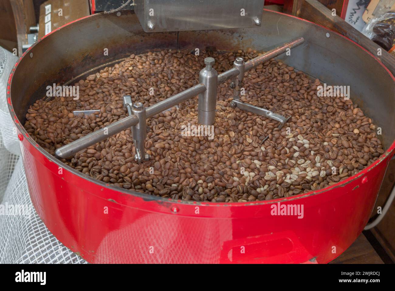 Coffee roasting with coffee beans in red roaster in a small factory ...