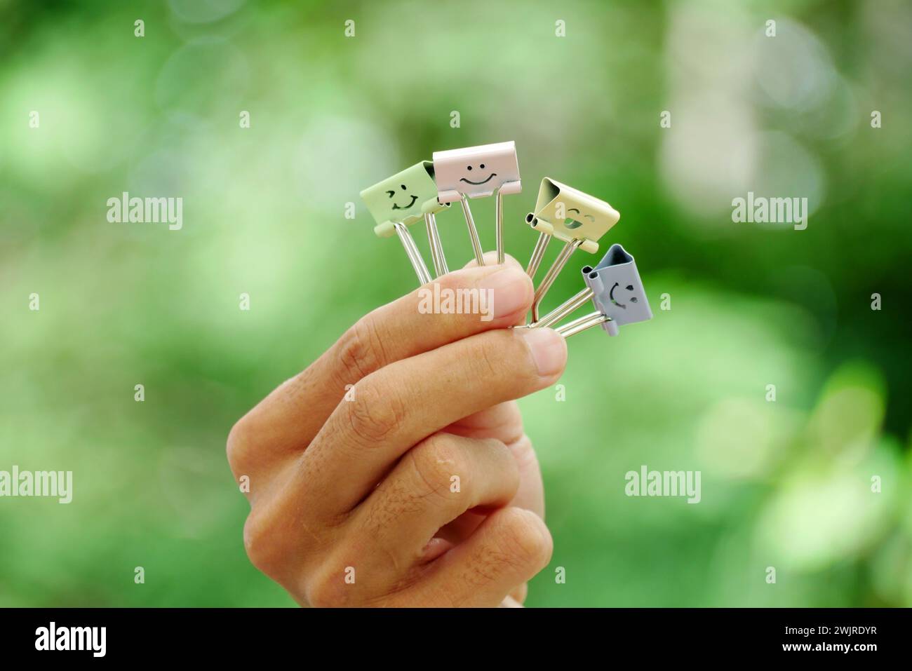 Happy emoticon paperclip on finger. Concept of positive thinking ...